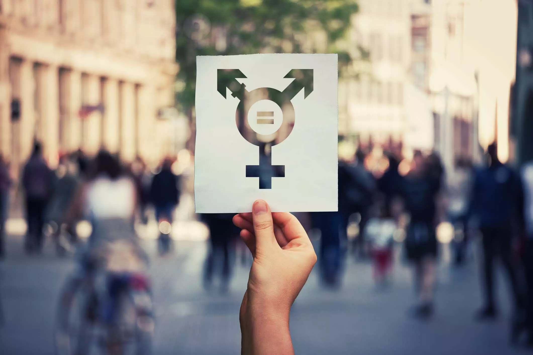 Ръка, държаща лист хартия със символ на трансджендър и знак за равенство вътре