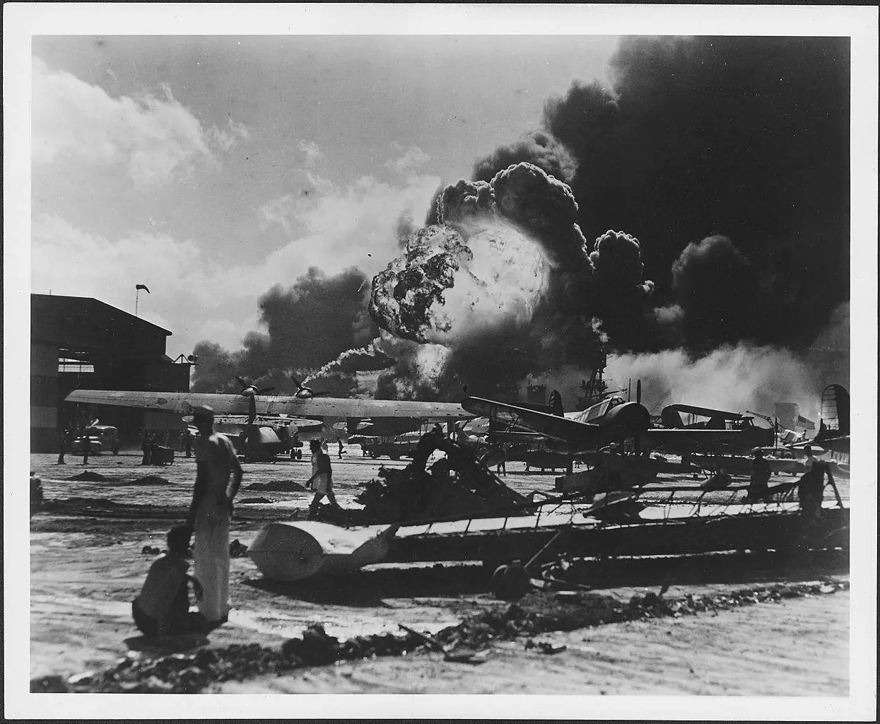 Fotografie námořní letecké stanice v Pearl Harbor poseté troskami po japonském útoku.
