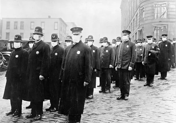 E Bild vu Polizisten zu Seattle déi Masken droen wärend der Spuenescher Gripp Pandemie 1918.