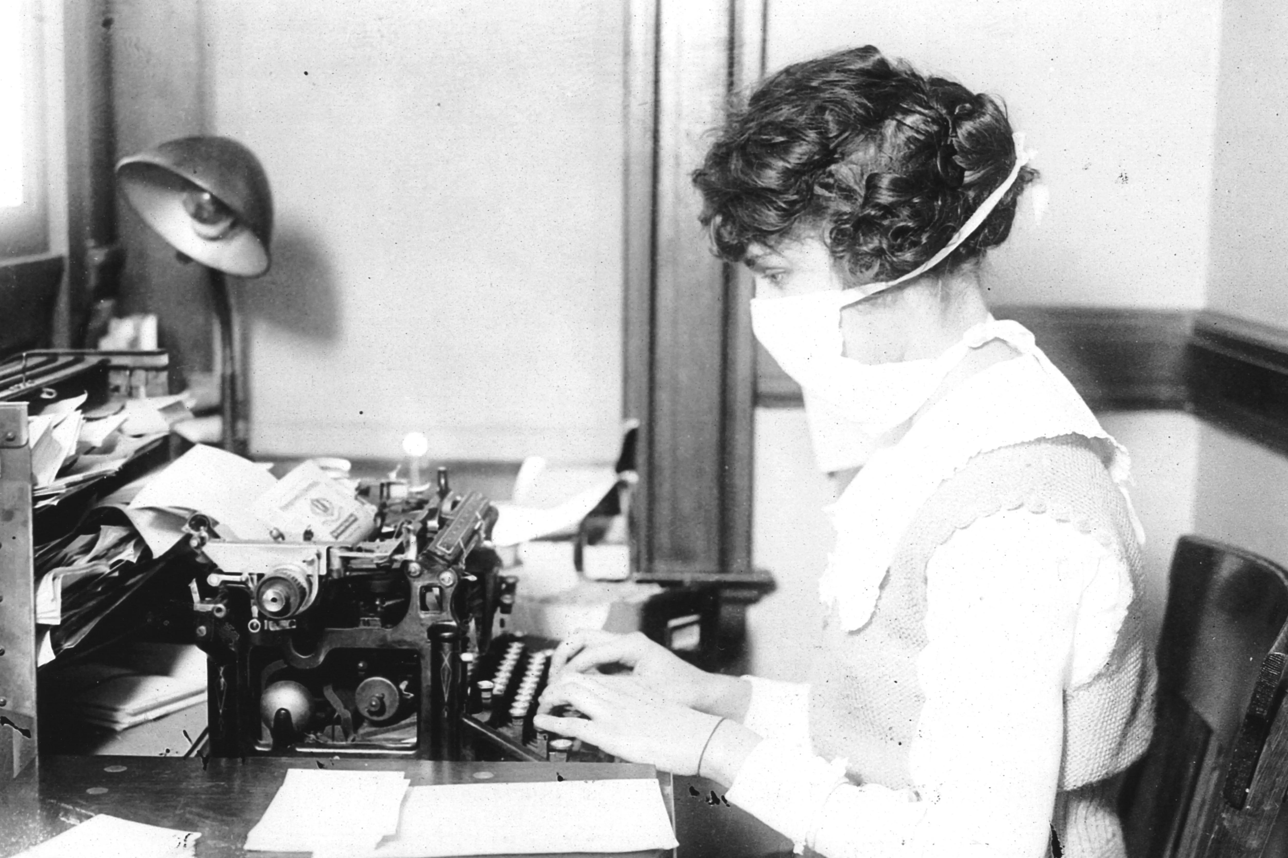 Wärend der 1918 Spuenescher Gripp Pandemic Typist Droen Mask, New York City. (16. Oktober 1918)