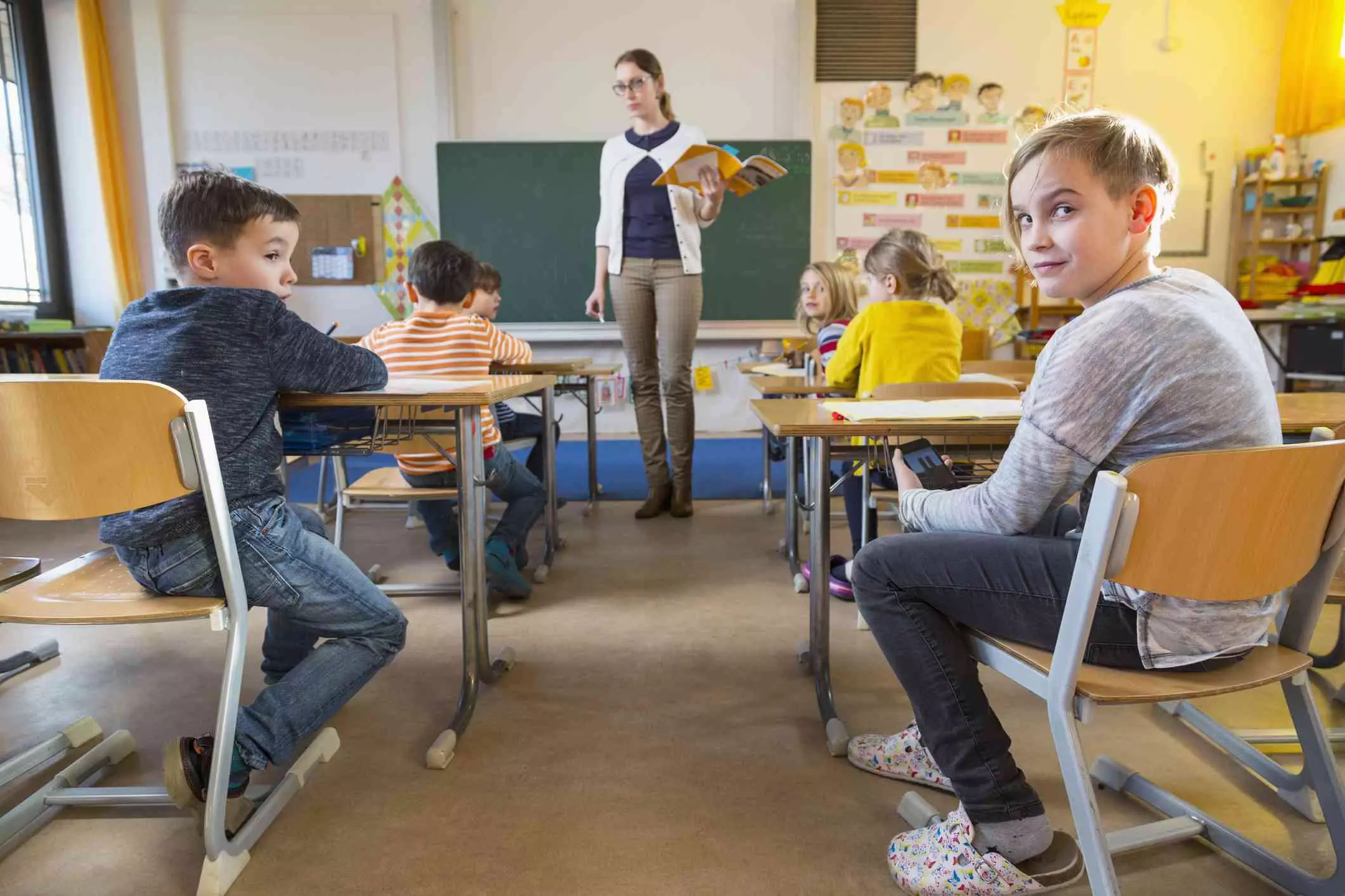 kinderen aan bureaus die terugkijken