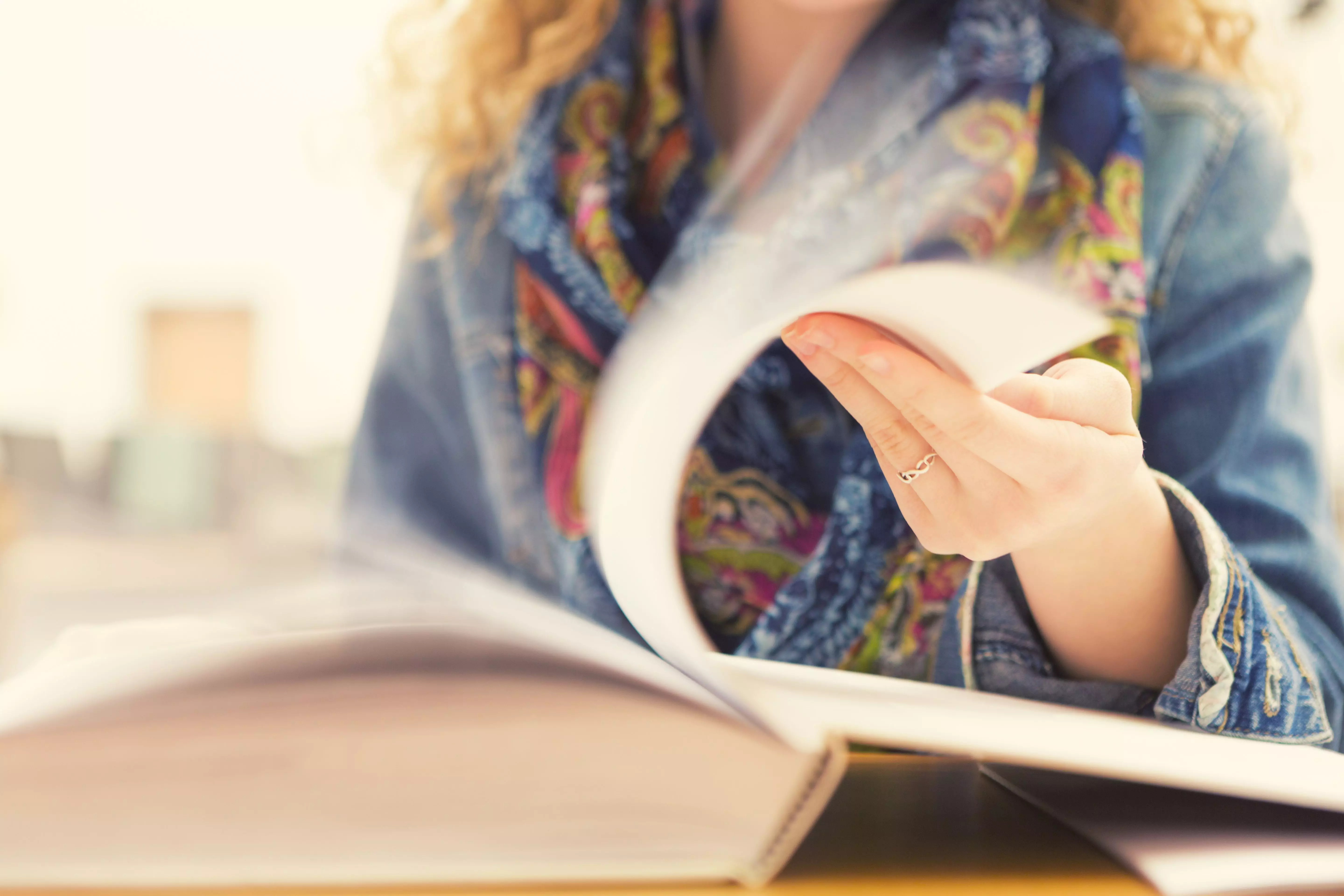 Studente che sfoglia il libro; movimento di voltare le pagine