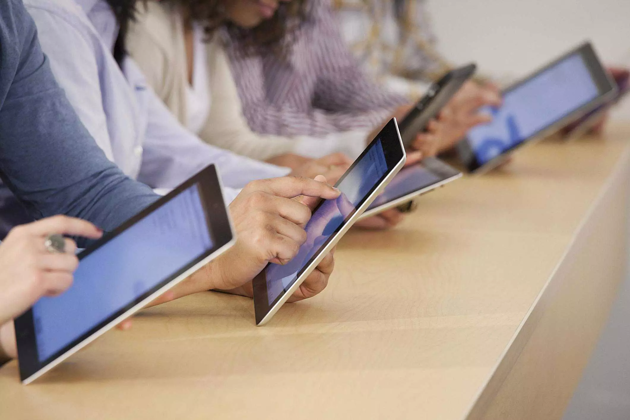 In groep minsken sjocht nei tablets