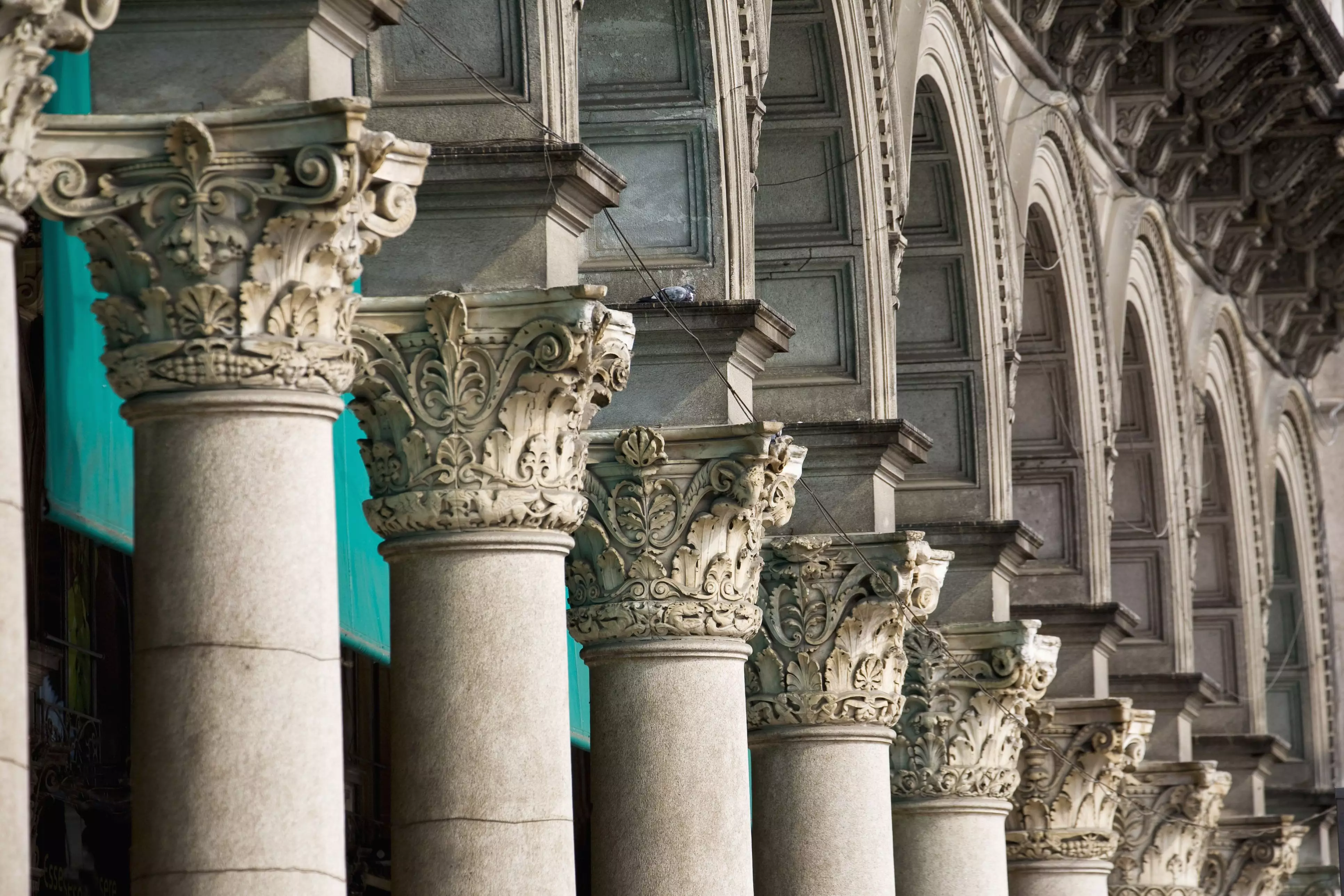 częściowy widok kolumnady dziewięciu głowic na szybach podtrzymujących imposty i kamienne łuki