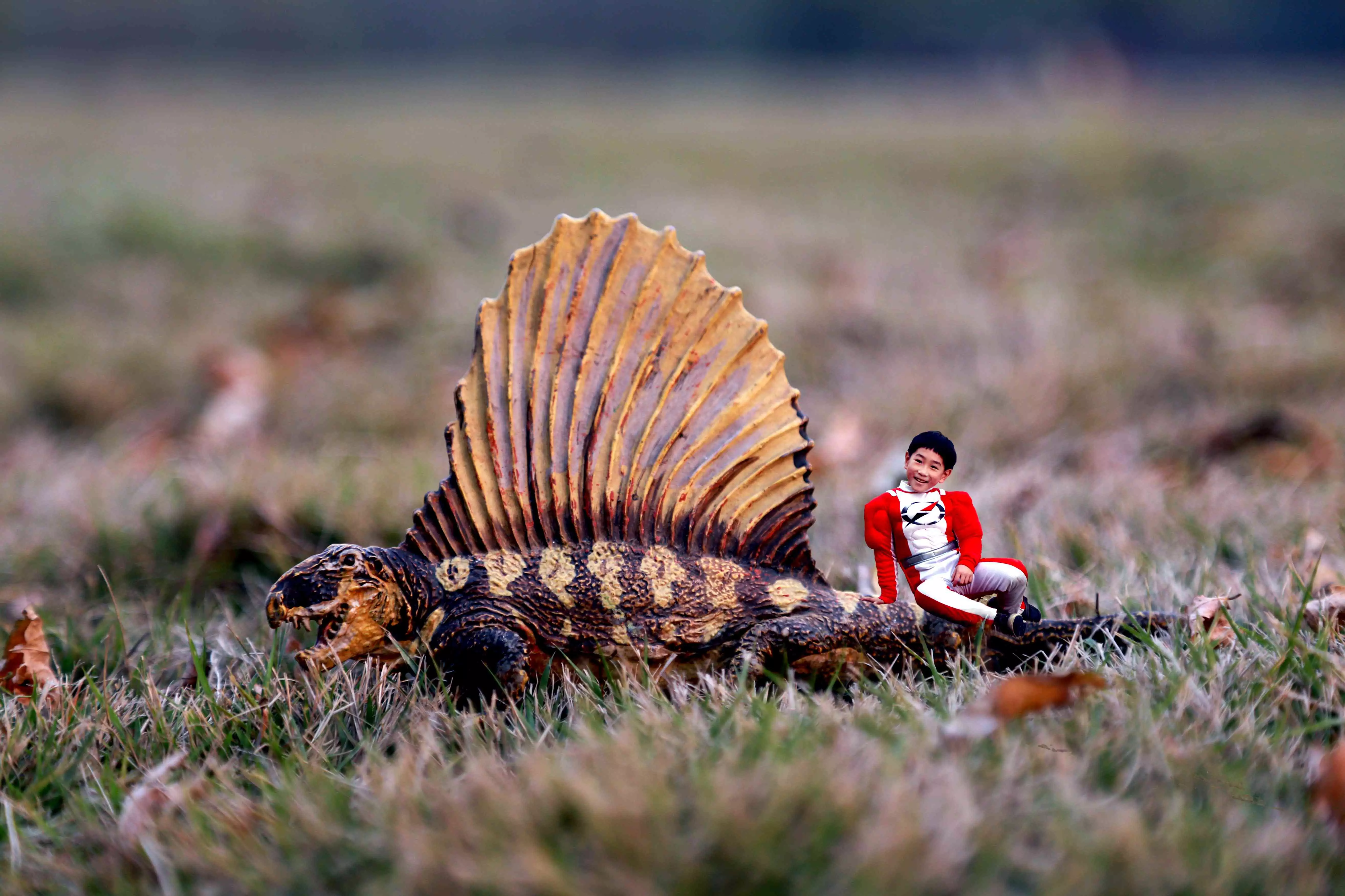 Budak leutik ngagunakeun fotografi trik pikeun pose sareng dimetrodon