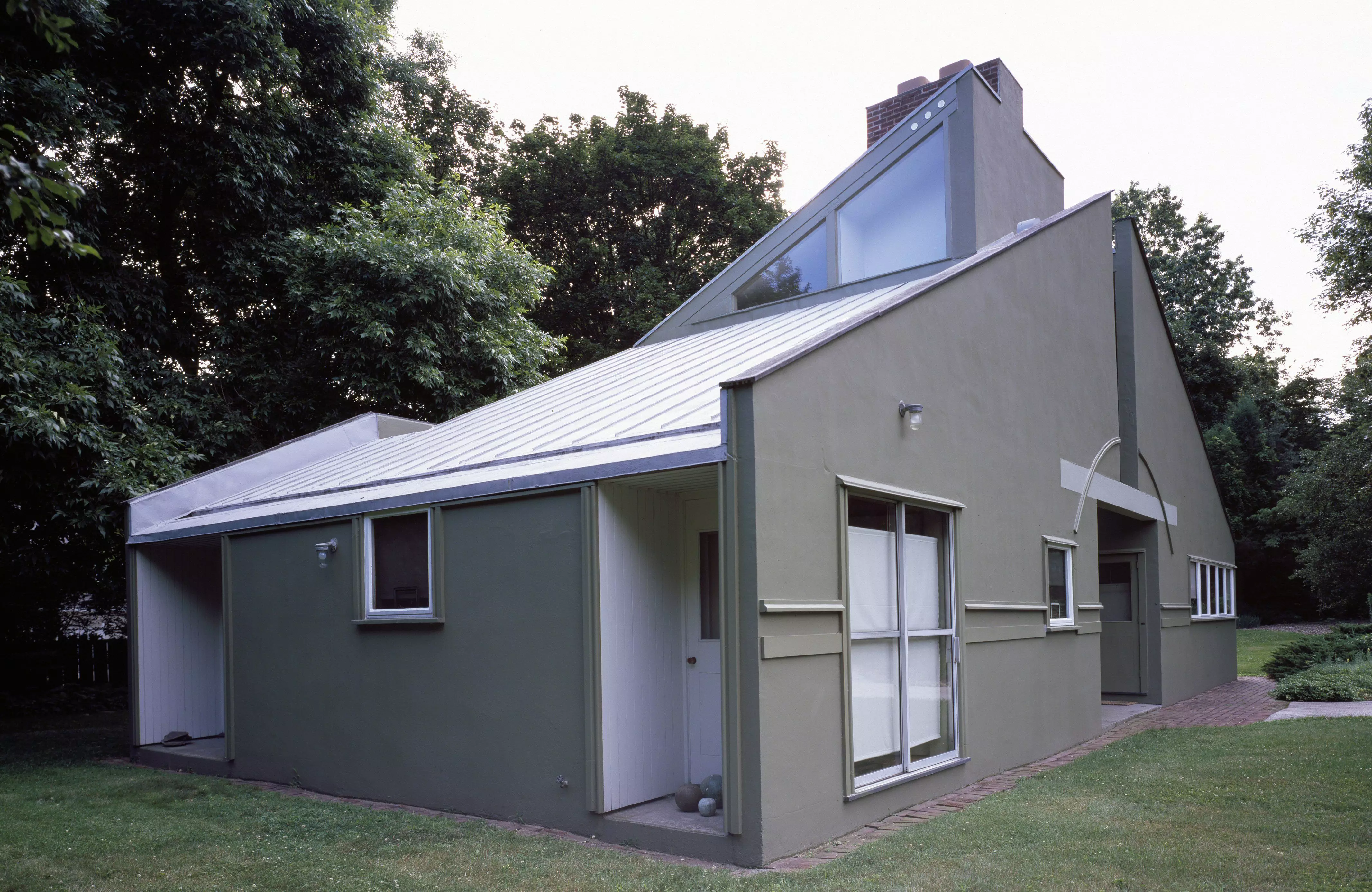 casa angular assimétrica com clarabóias e parapeitos estendidos