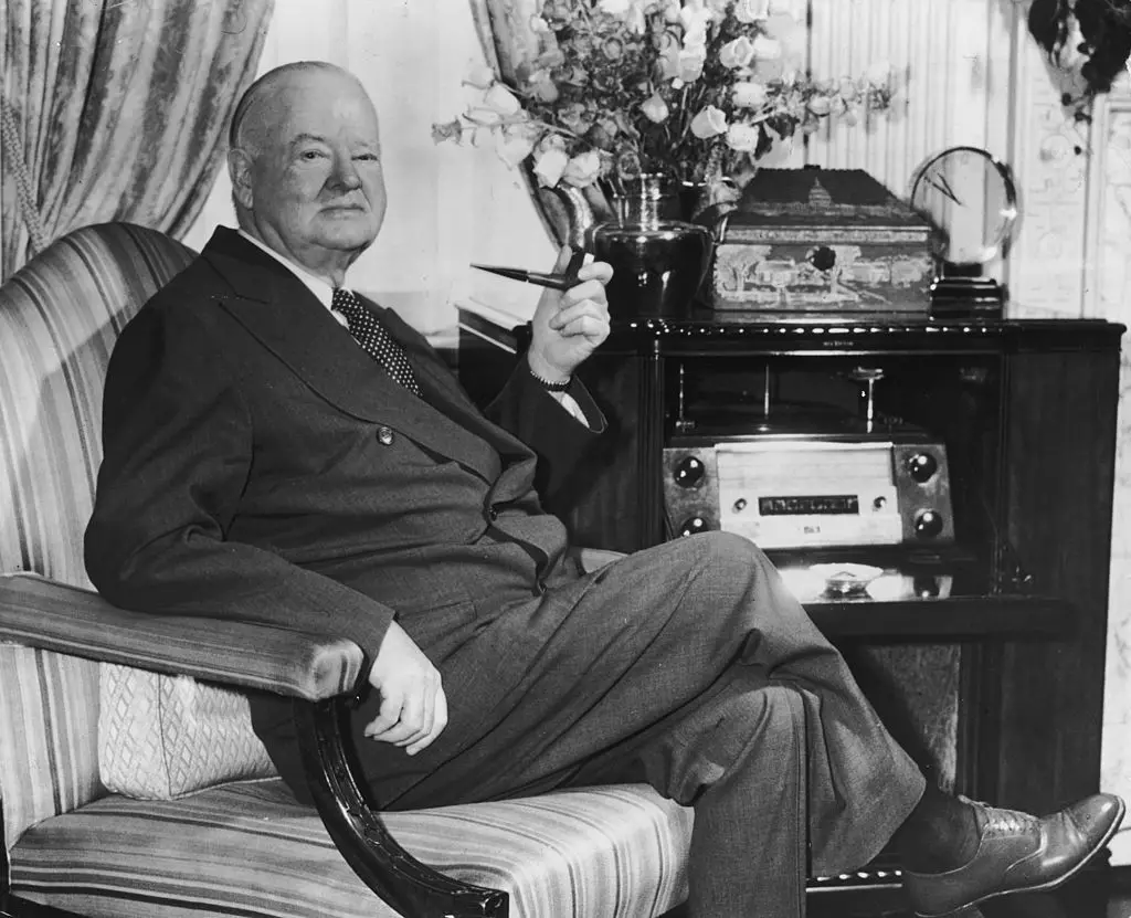1962 inguruan: Herbert Hoover (1874 - 1964) estatubatuar presidente ohiaren erretratua besaulki batean eserita tutu batekin bere suitean Waldorf Towers-en, New York hirian.