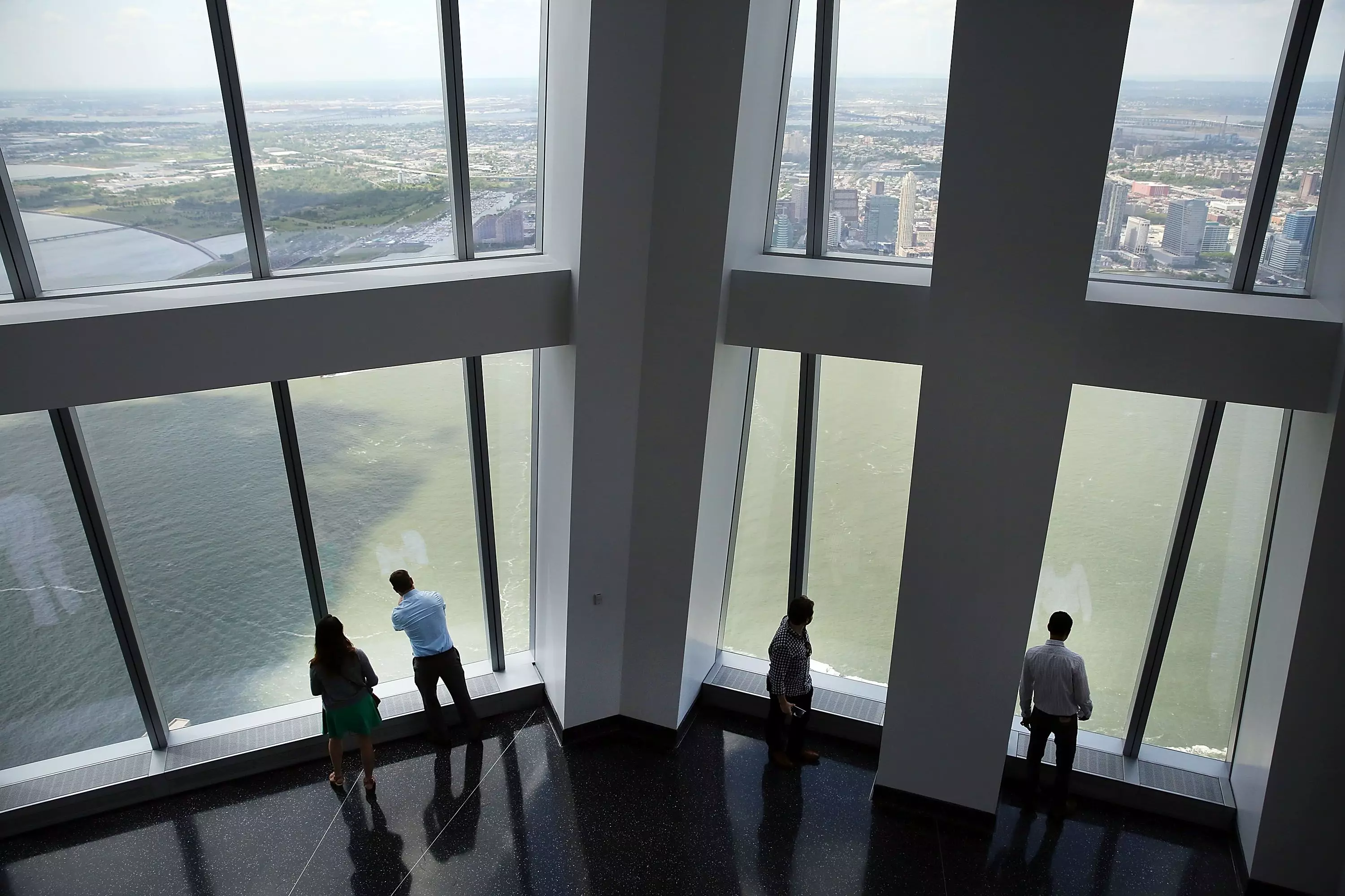 Orang-orang melihat keluar jendela dua lantai One World Observatory di 1WTC, terbuka untuk umum