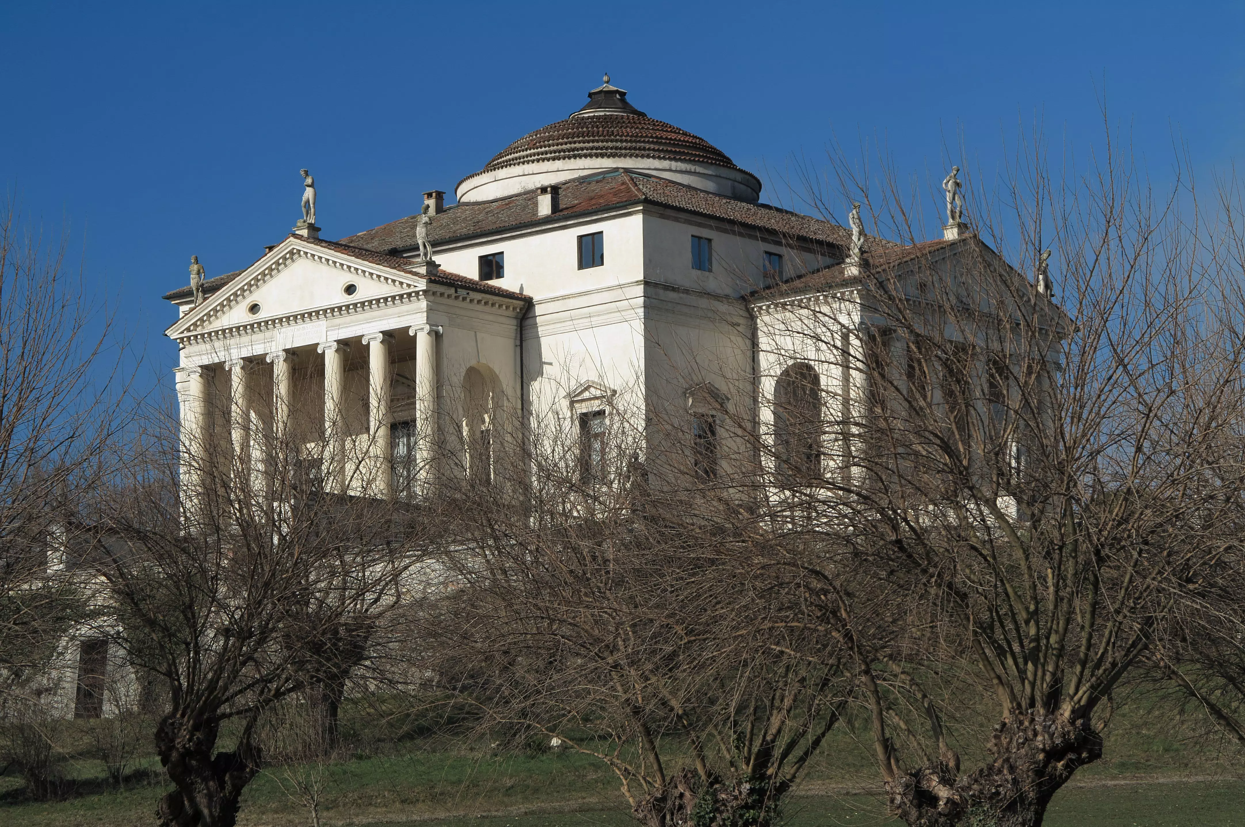 villa in pietra su collina rurale, piazza con quattro portici per lato, cupola centrale, simmetrica