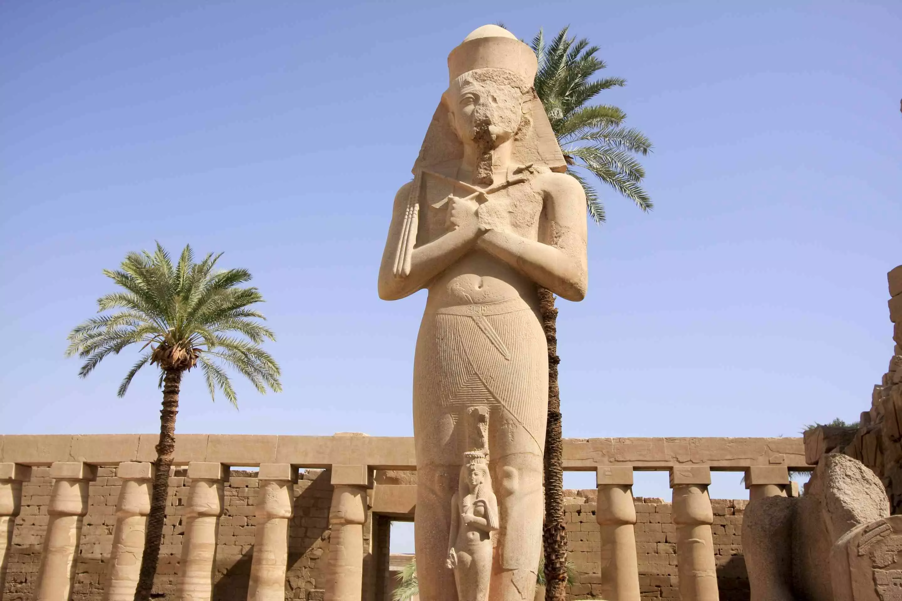 Ŝtona statuo de Ramses II en la korto de ruinoj