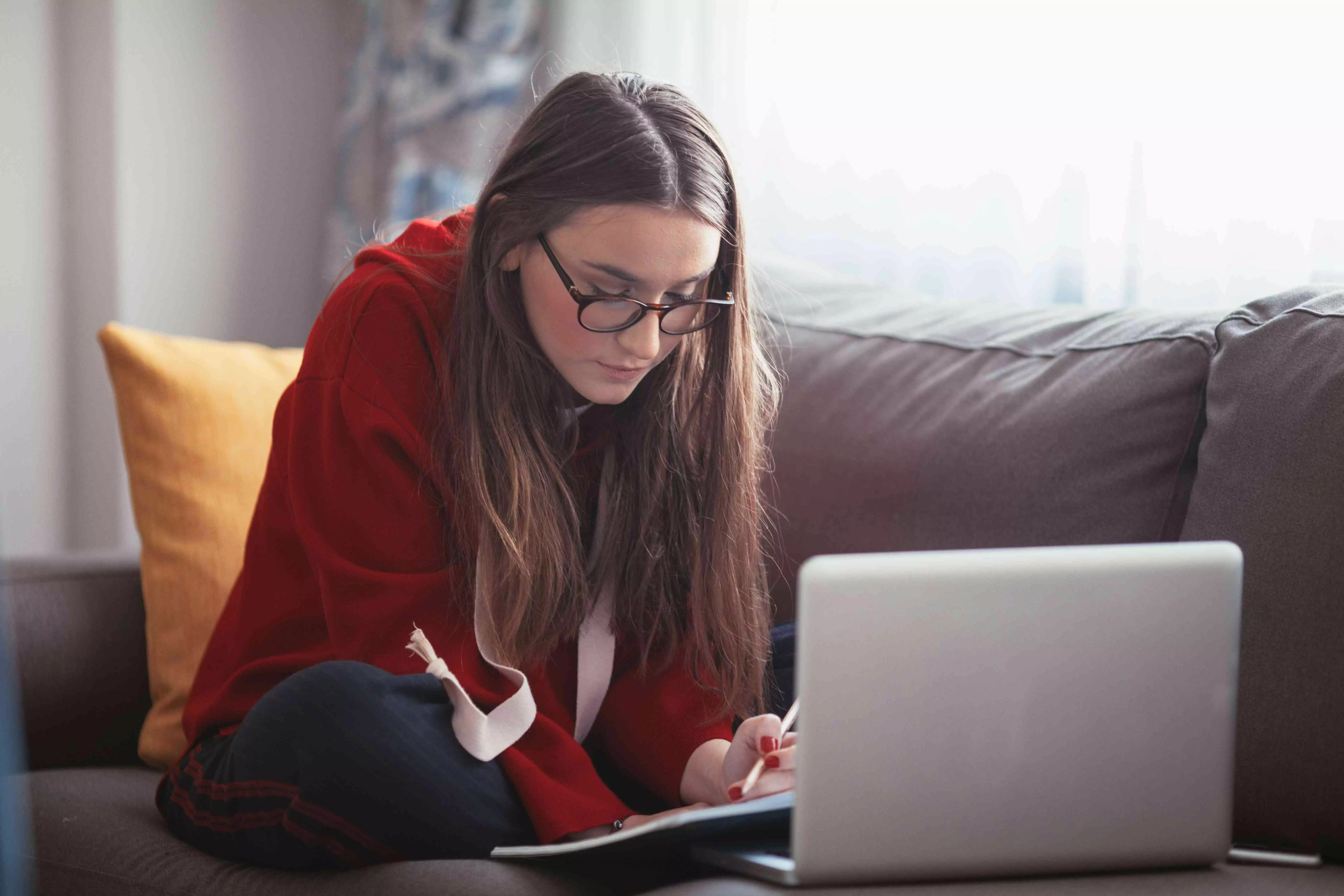 Donna che studia sul divano