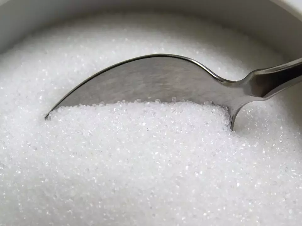 Feche uma colher mergulhando no açúcar.