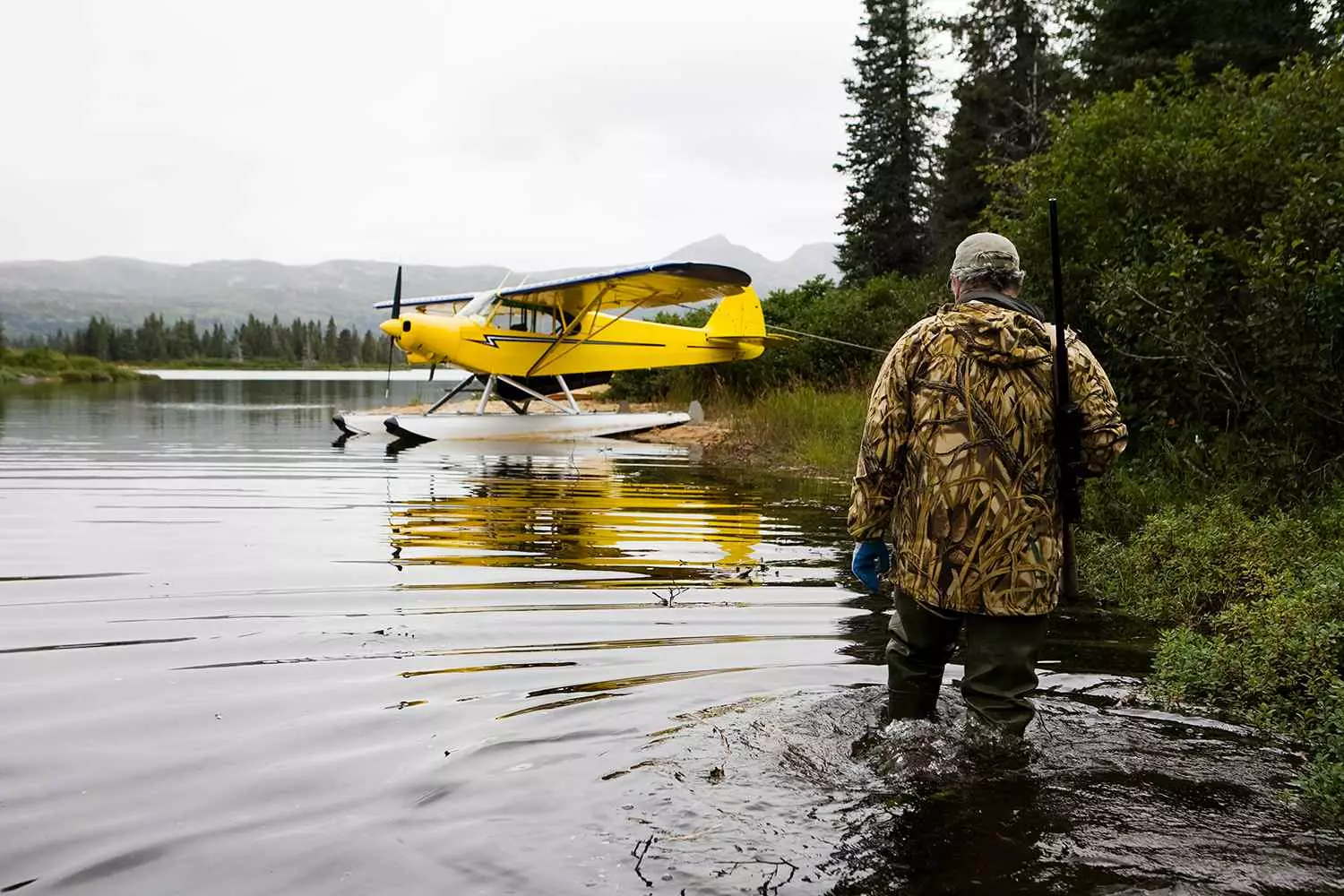 Hunter Wades con su Rife al hombro en el lago Iliamna