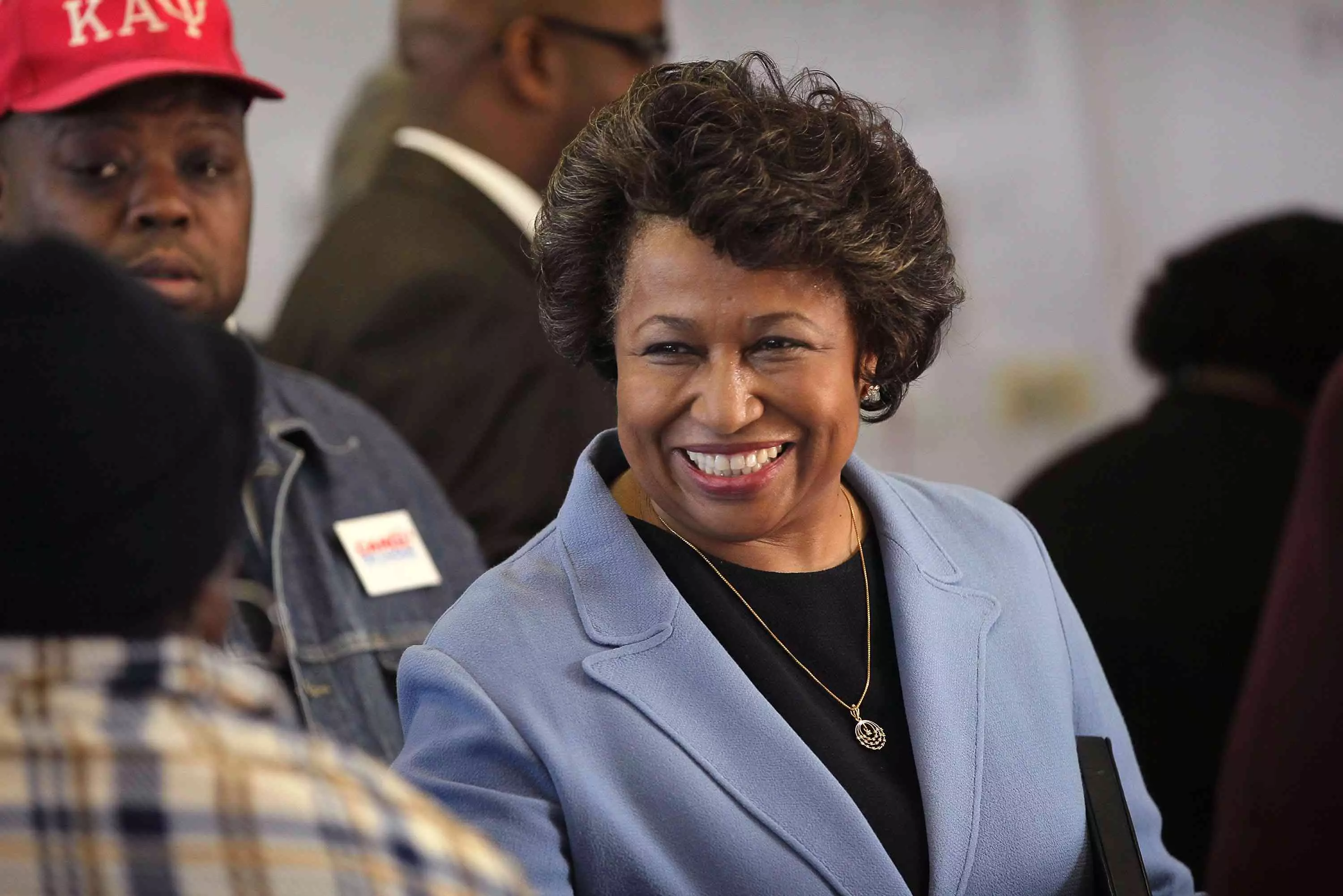 Carol Moseley Braun draagt een blauw colbert en lacht naar een man