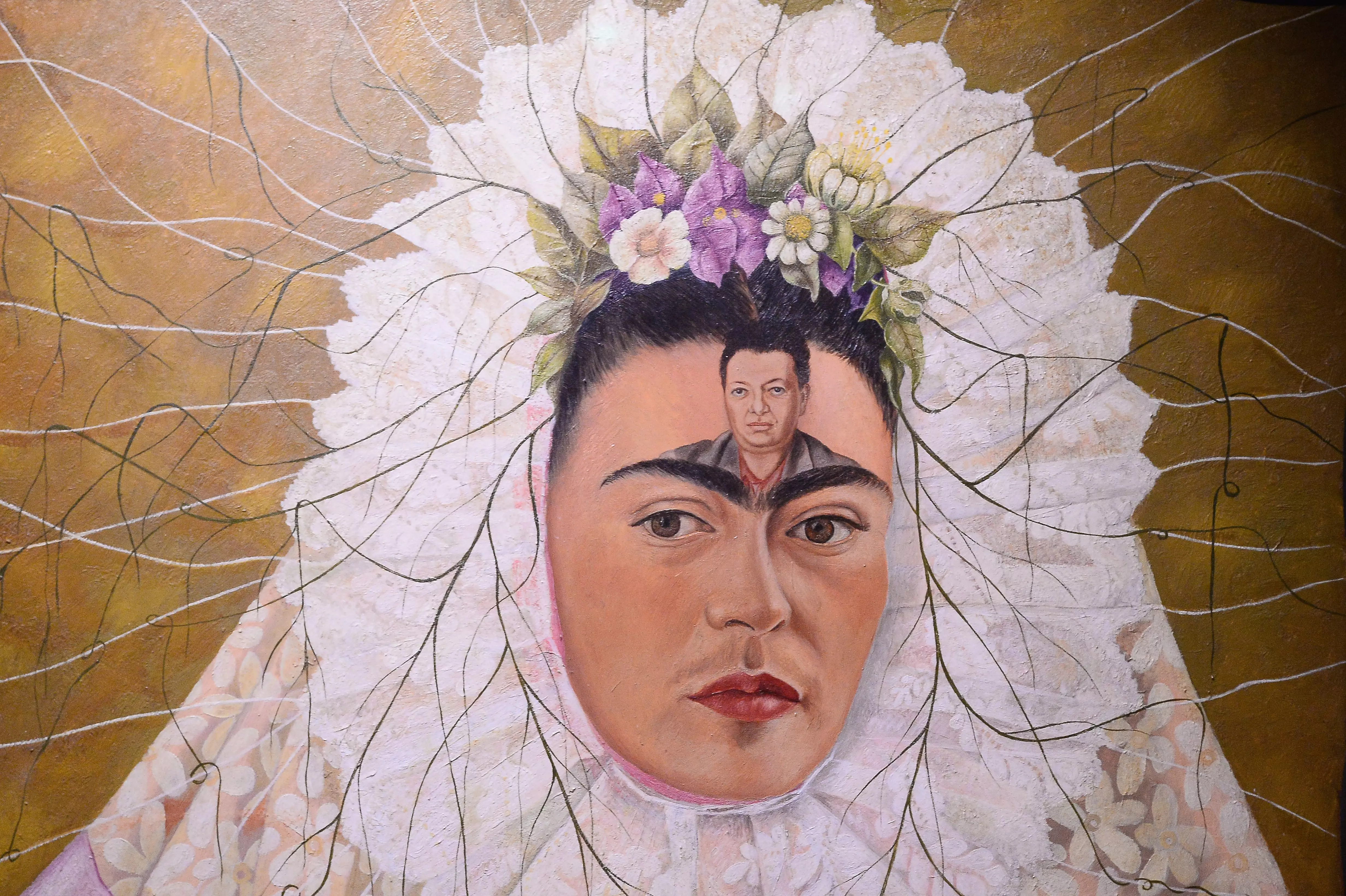 डिएगो रिवेरा के चेहरे वाली महिला अपने माथे पर रंगी हुई है।