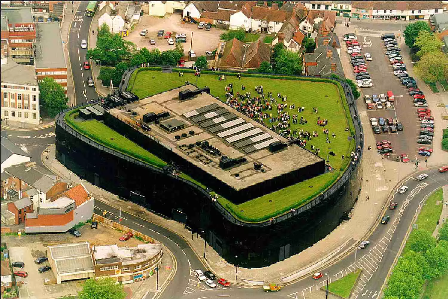 воздушен поглед на асиметрична ниска зграда со масивен зелен покрив