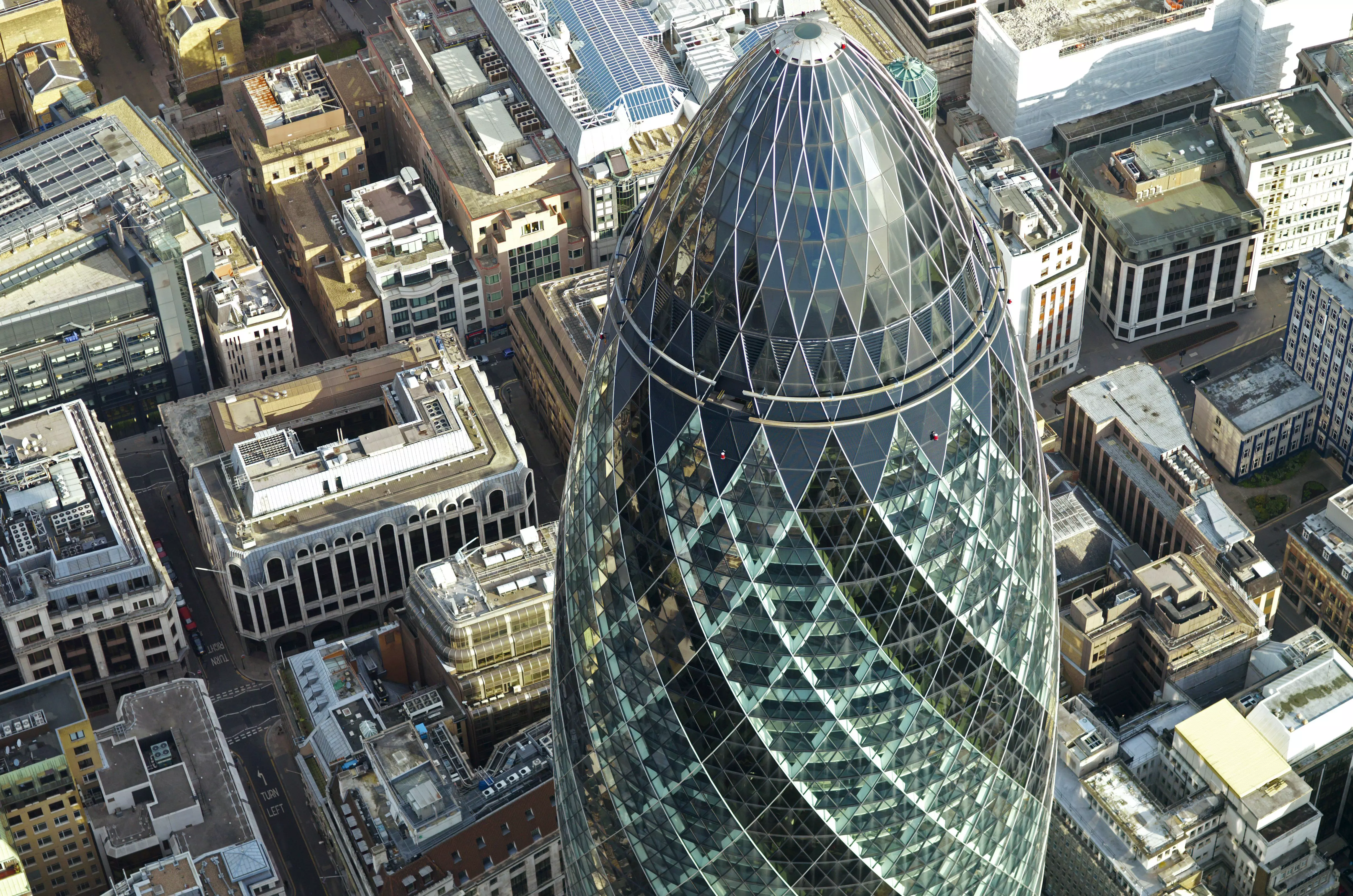 vista aérea olhando para baixo em edifícios baixos retangulares tradicionais em torno de um moderno arranha-céu com aparência de míssil