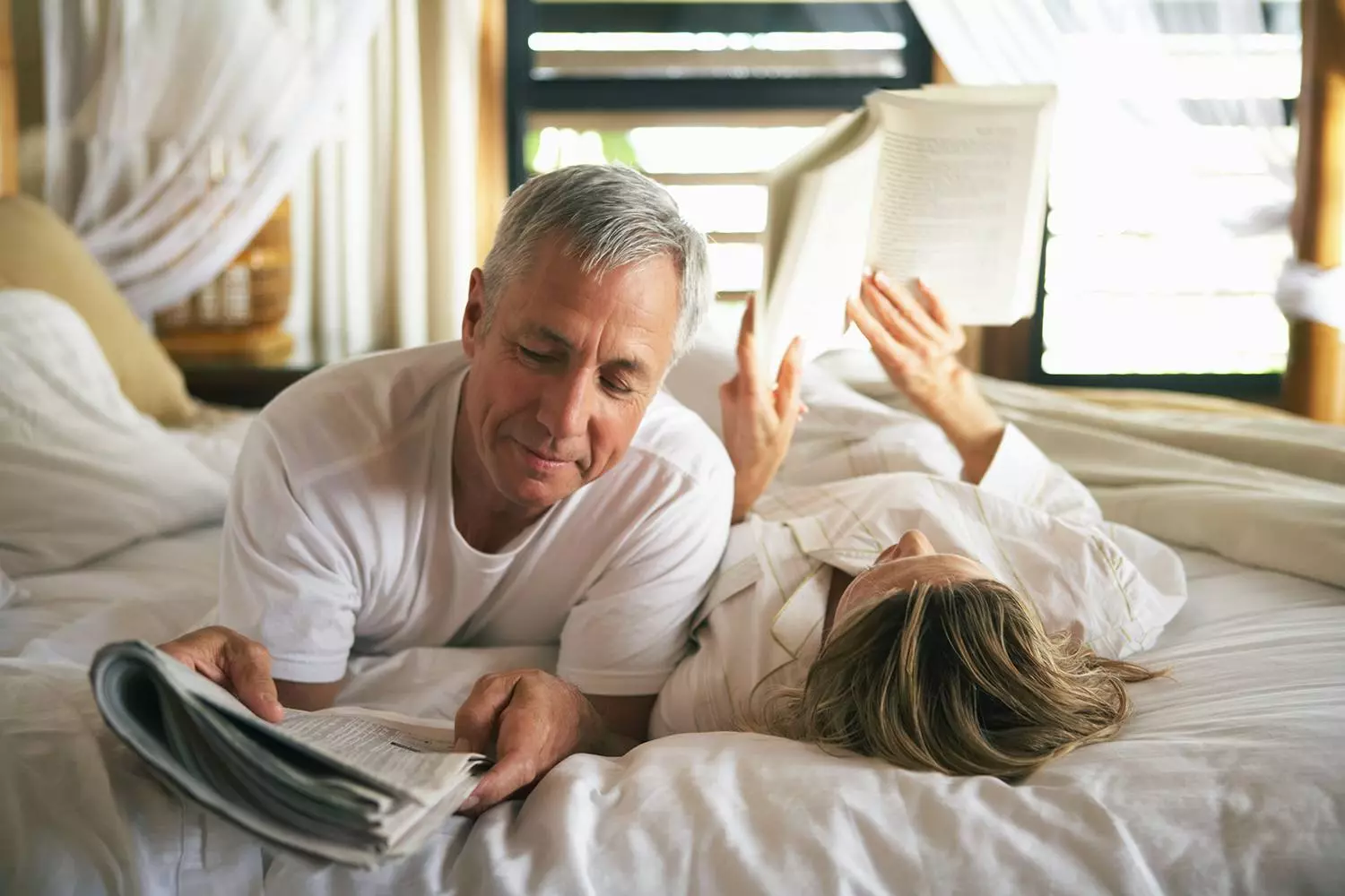 老年夫婦在床上看書，特寫。