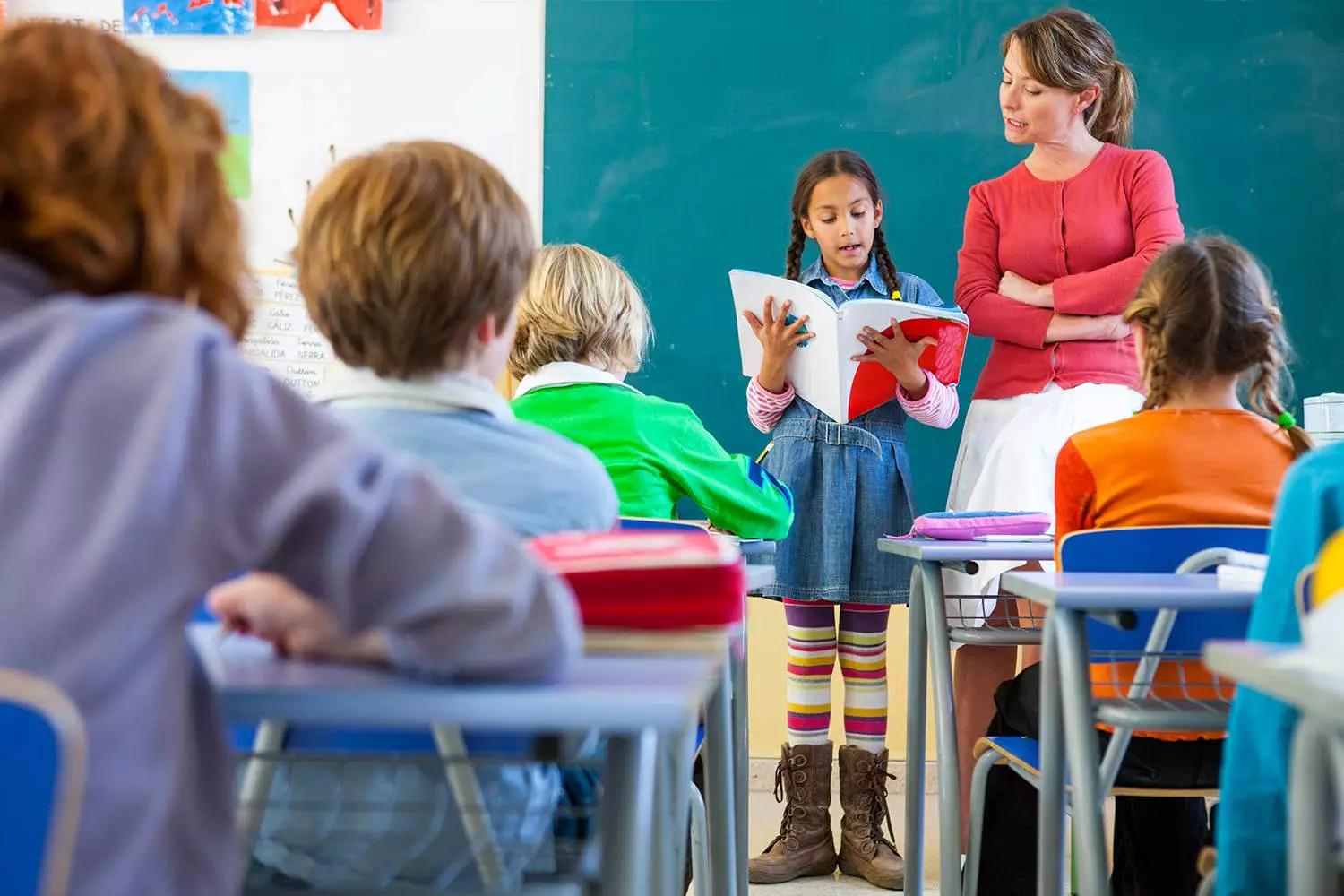 Laerskoolmeisie lees voor in die klaskamer