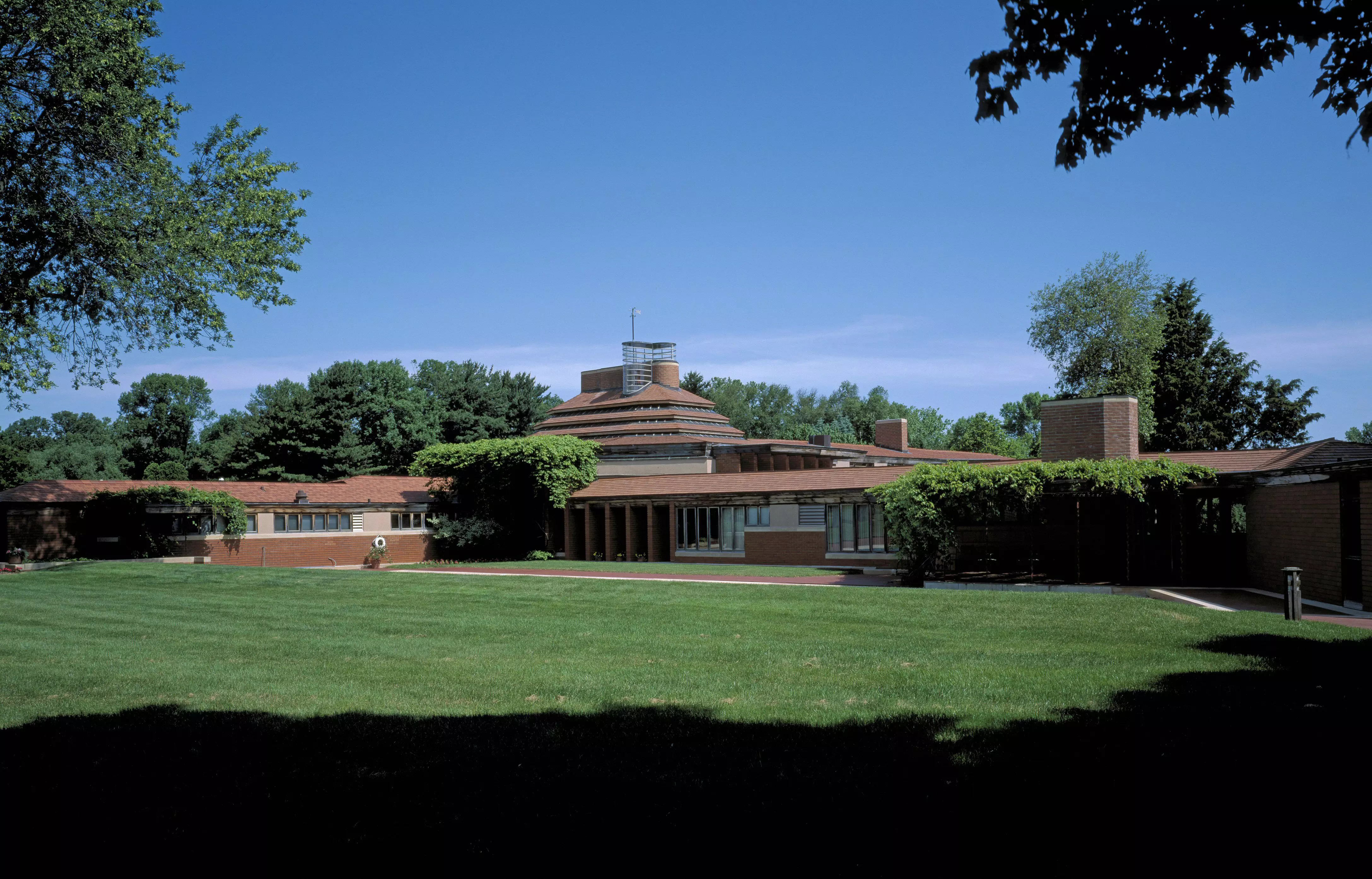 Wright's Wingspread, het Herbert F. Johnson House, is organisch laag bij de grond, baksteen en met een centrale schoorsteen