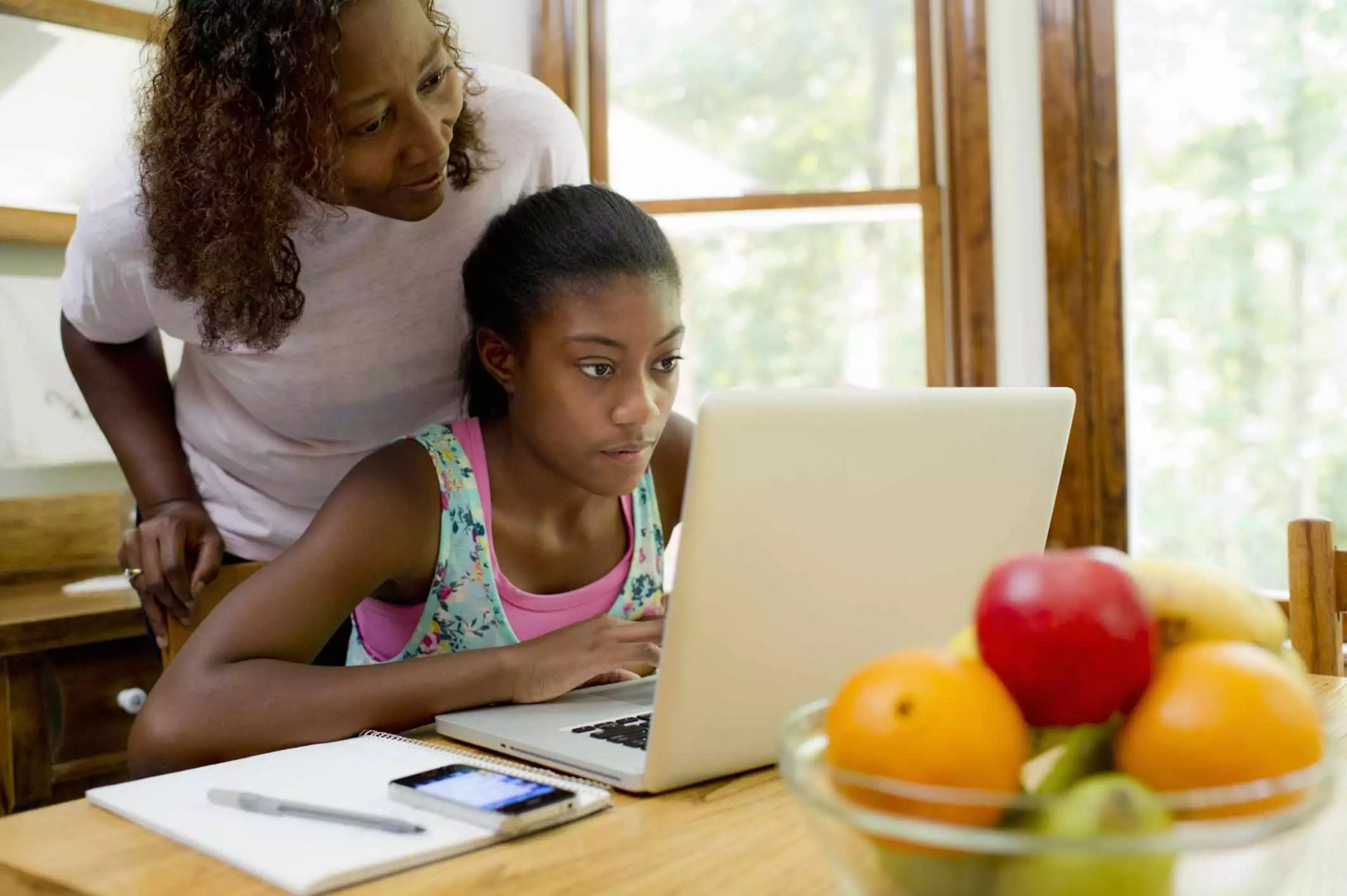 Afroamerikanesch weiblech Teenager studéiert mat Mamm