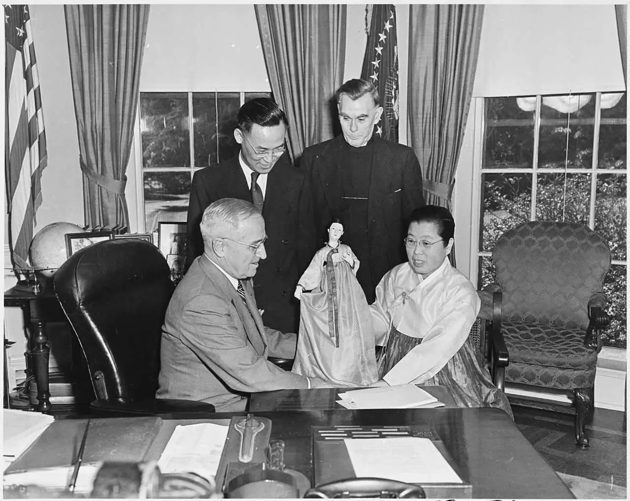 Prezidan Truman nan Biwo Oval la, k ap resevwa yon poupe nan men Doktè Helen Kim, yon edikatè Koreyen