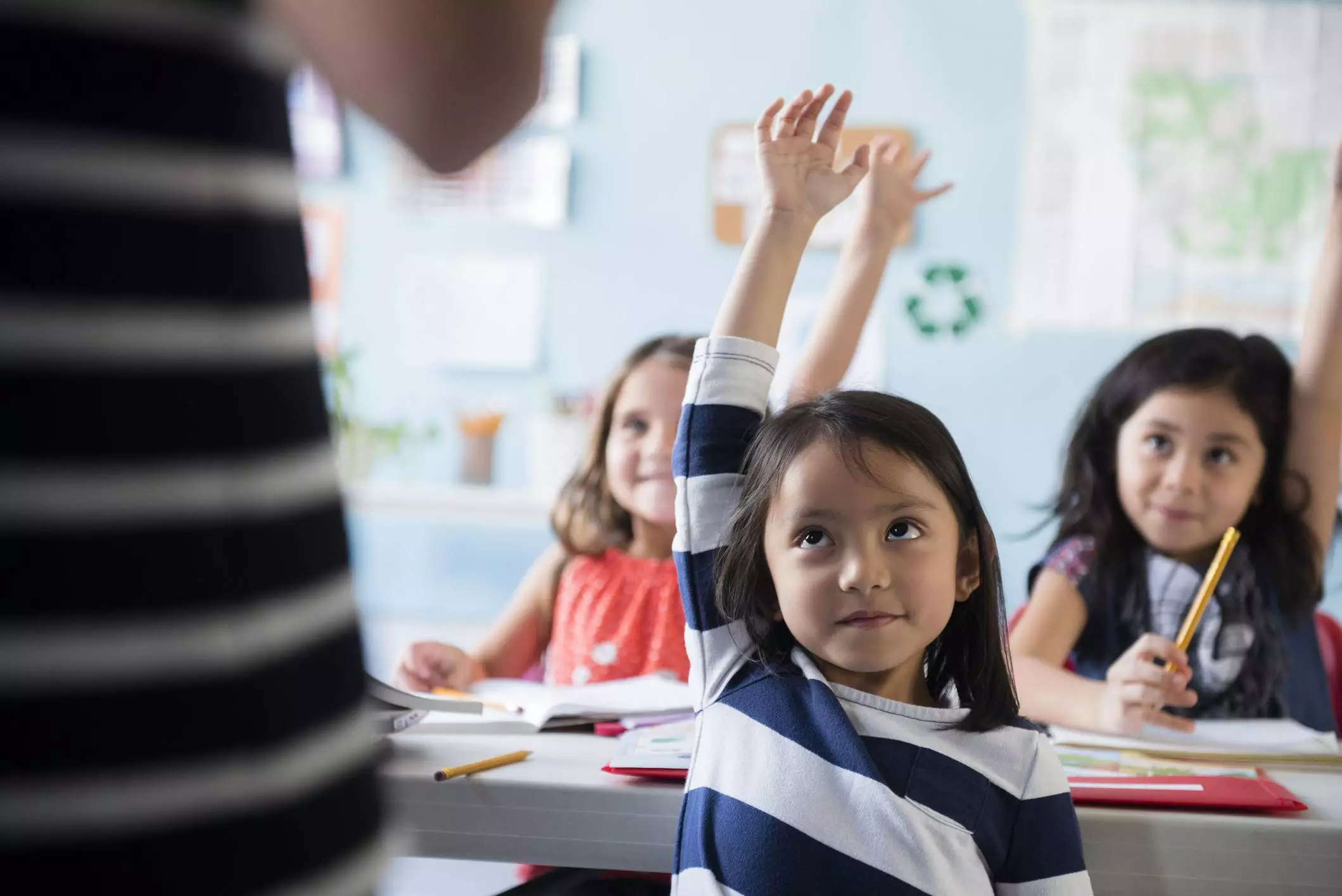 Kanak-kanak di dalam kelas dengan tangan diangkat