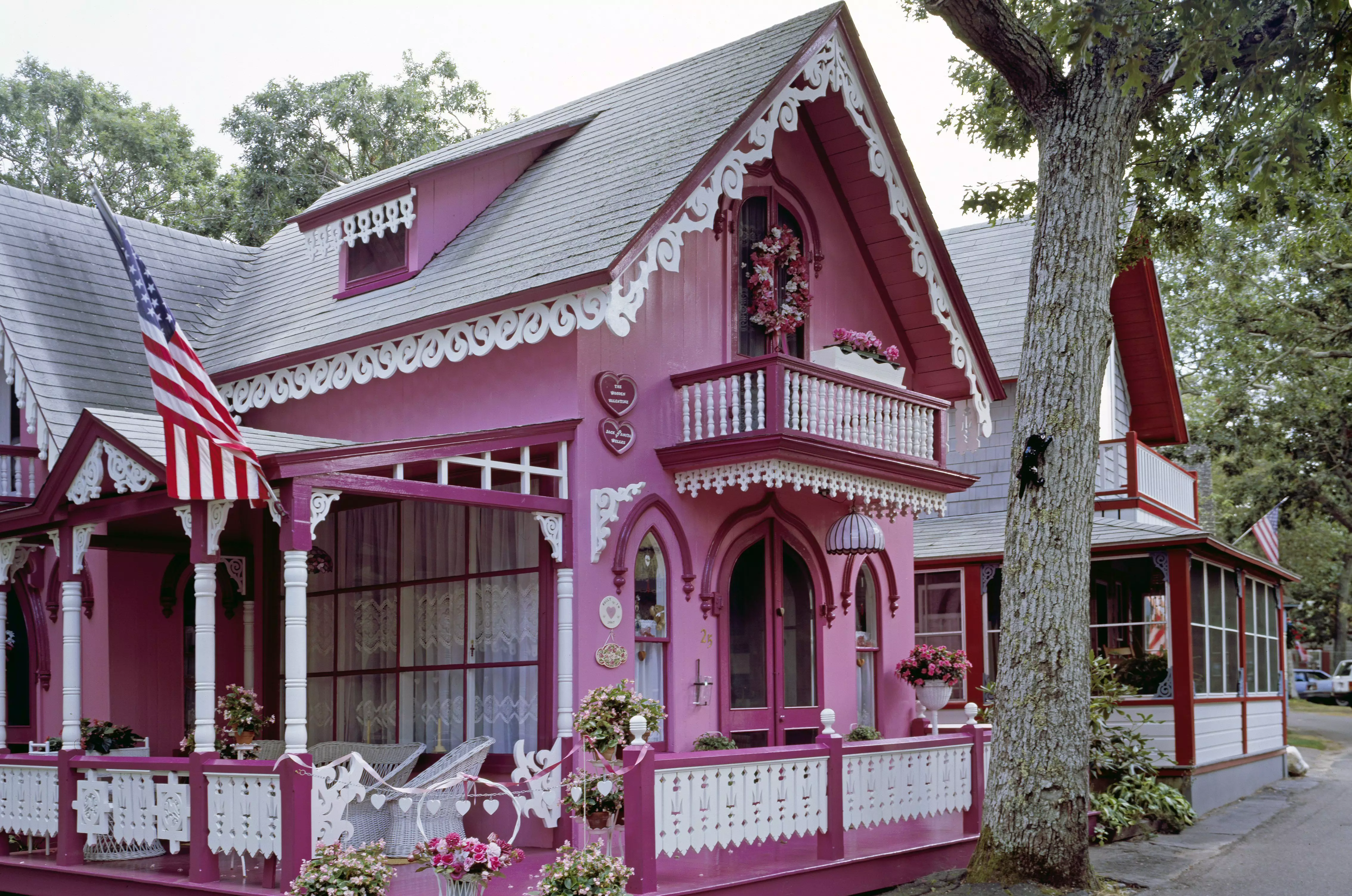 Rausvai violetinis Gotikinis dailidės namelis, stačiais frontonais, baltais meduolių apdaila, puošnus