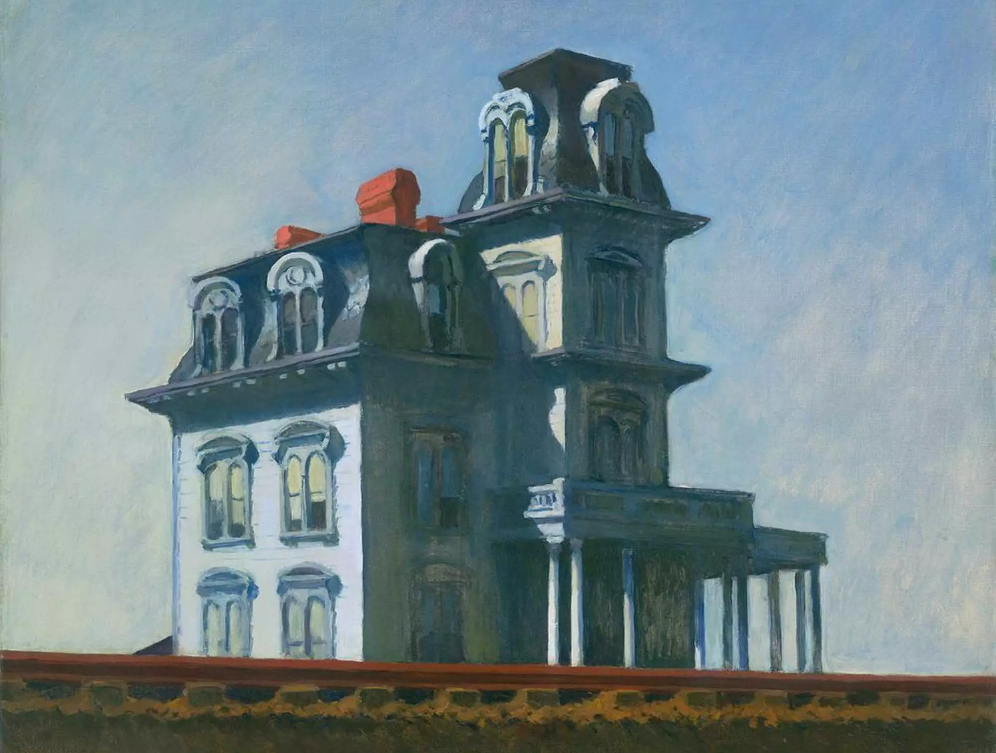 Hohes viktorianisches Haus mit Mansardendach vor einem graublauen Himmel