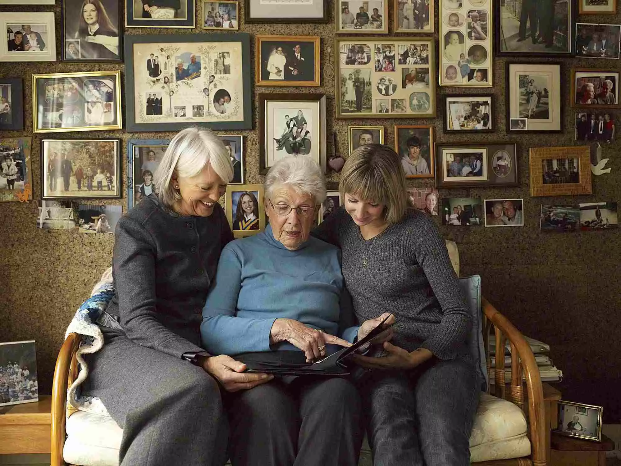 Trois générations de femmes regardant un album photo