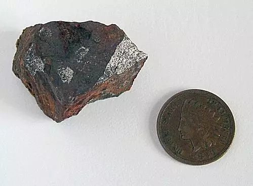 Non-crystallized magnetite sa tabi ng isang barya.