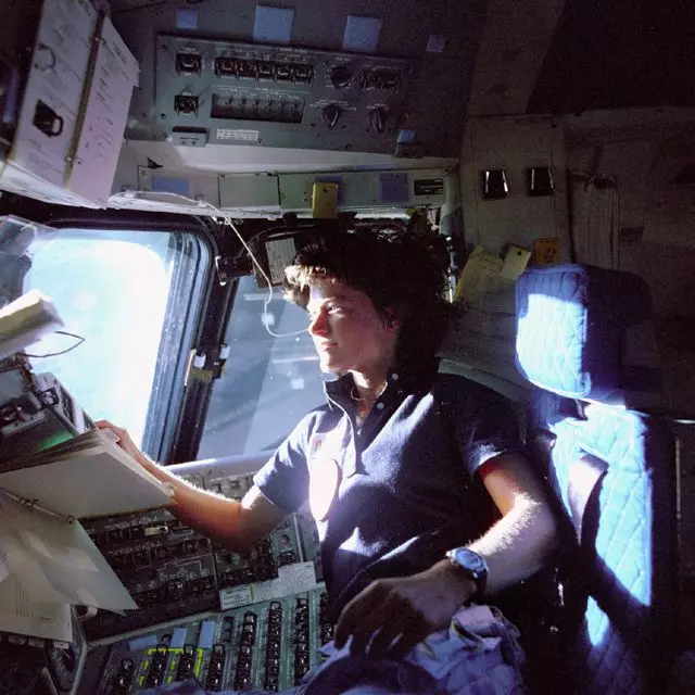 અવકાશયાત્રી સેલી ફ્લાઇટ ડેક પર પાઇલટની ખુરશીમાં સવારી કરે છે.