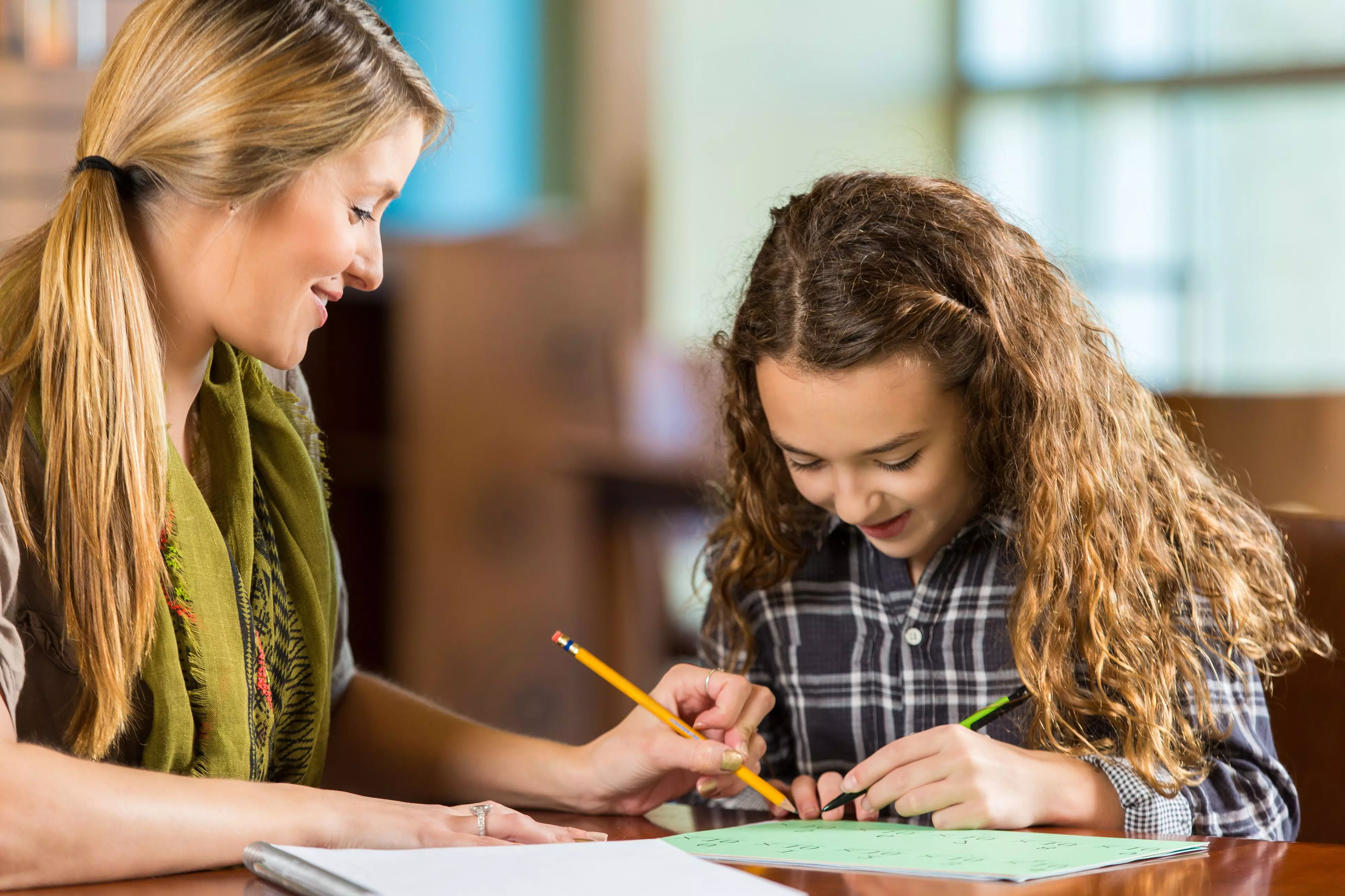 Általános korú lány matematikai házi feladatot vagy otthoni iskolai feladatot csinál