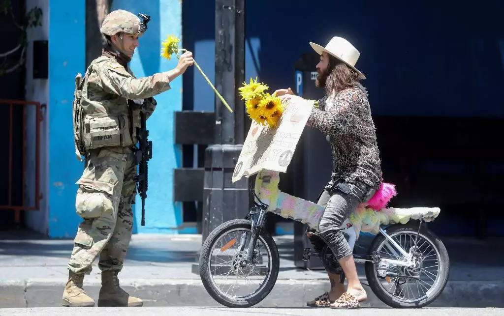 Een soldaat van de National Guard ontvangt een bloem van een demonstrant tijdens een vreedzame demonstratie over de dood van George Floyd in Hollywood op 3 juni 2020.