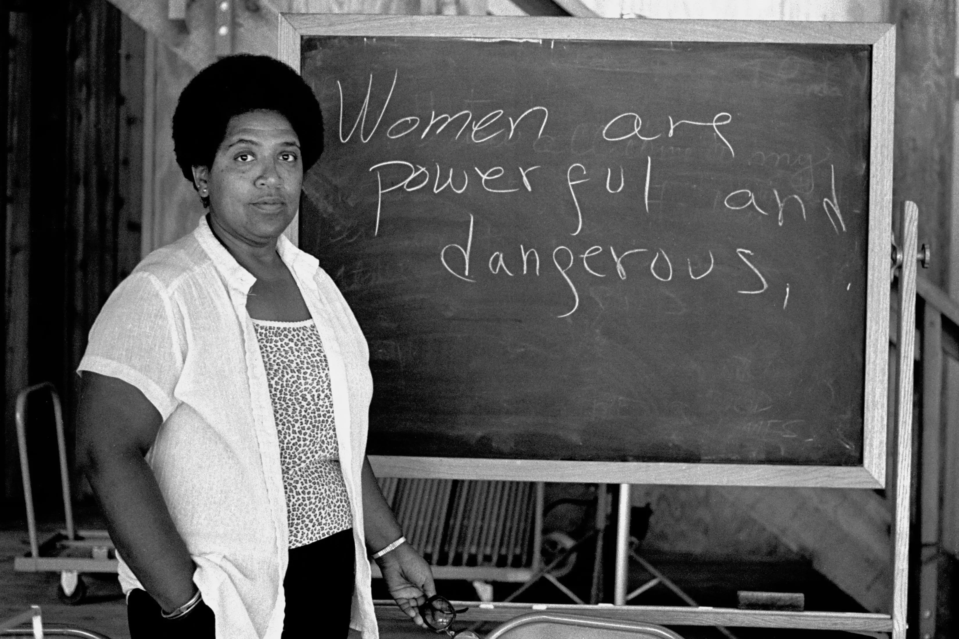Audre Lorde prednáša, slová na tabuli sú Ženy sú mocné a nebezpečné