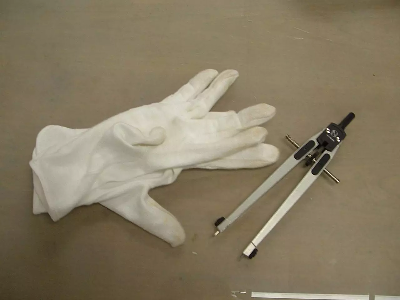קליפרים וכפפות כותנה משמשים במהלך ניתוח חפצים.