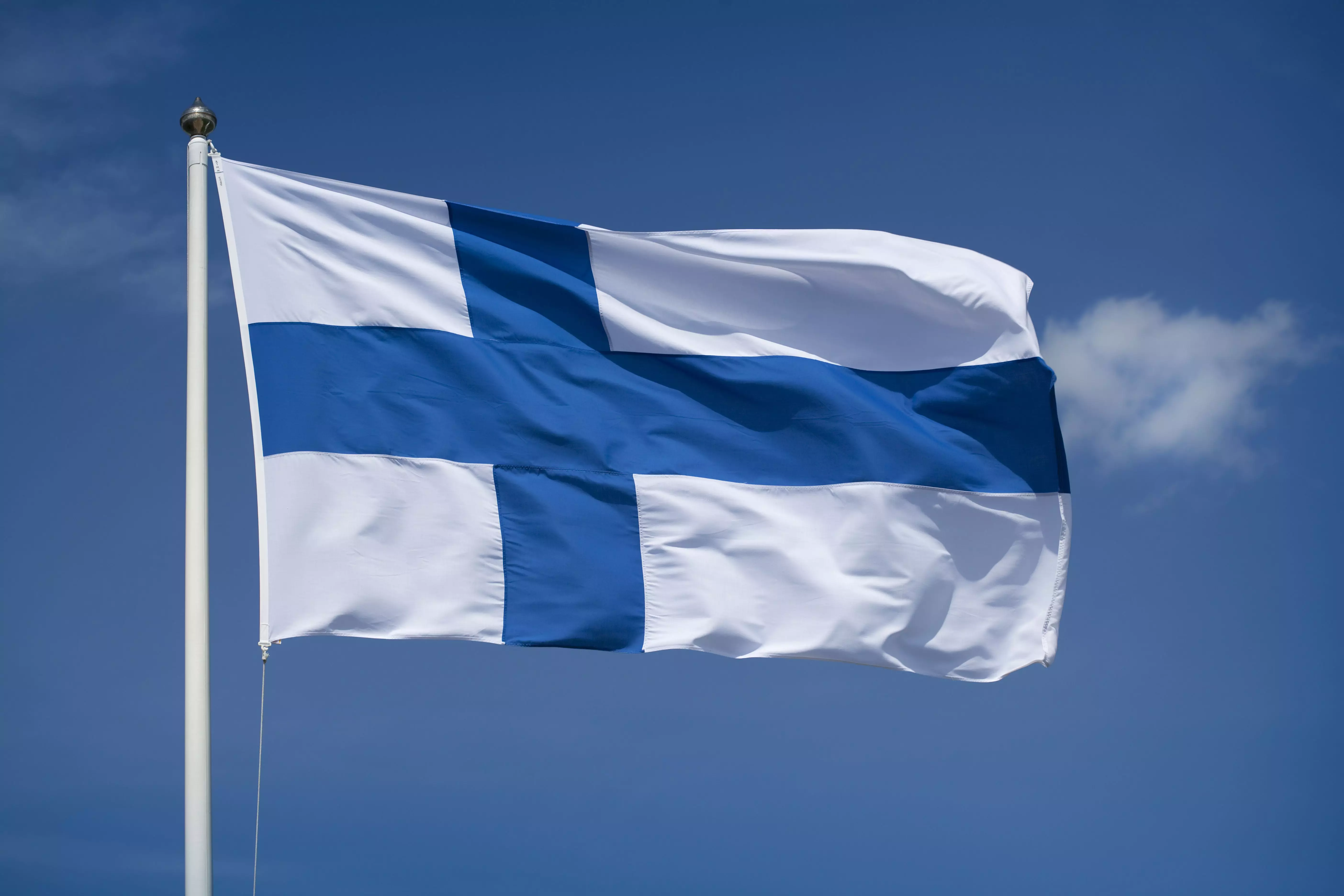 Finlandiako bandera altxatua zeru urdineko hondoarekin