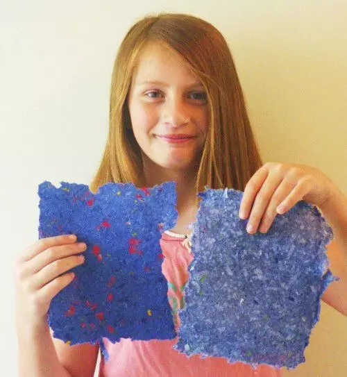 djevojka drži ručno izrađeni plavi papir