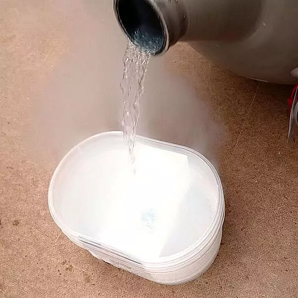Flüssiger Stickstoff wird aus einem Dewar gegossen.