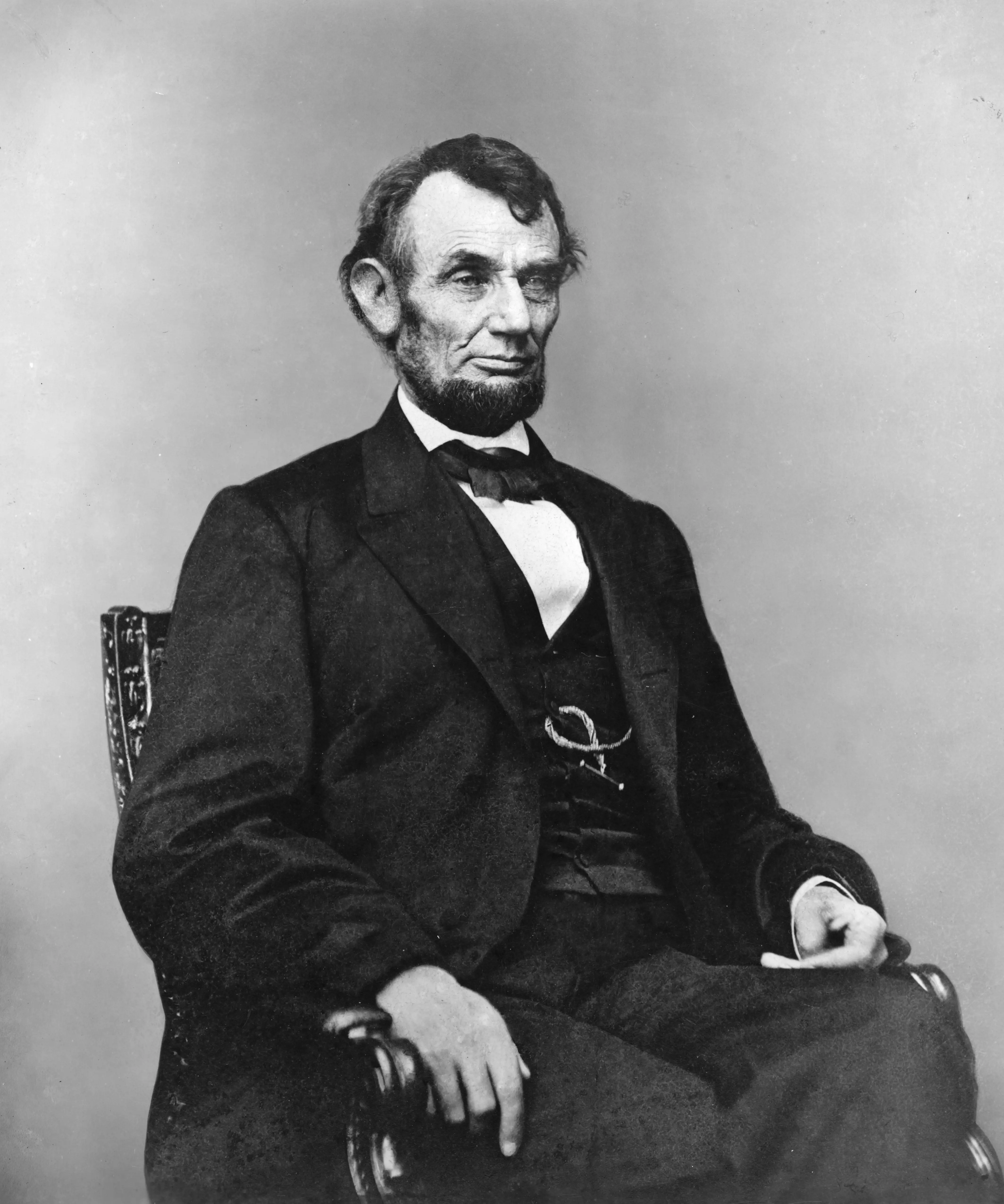 Abraham Lincoln, Driekwart-lengteportret, sittend, regs; Hare geskei aan Lincoln se regterkant. 1864 9 Feb