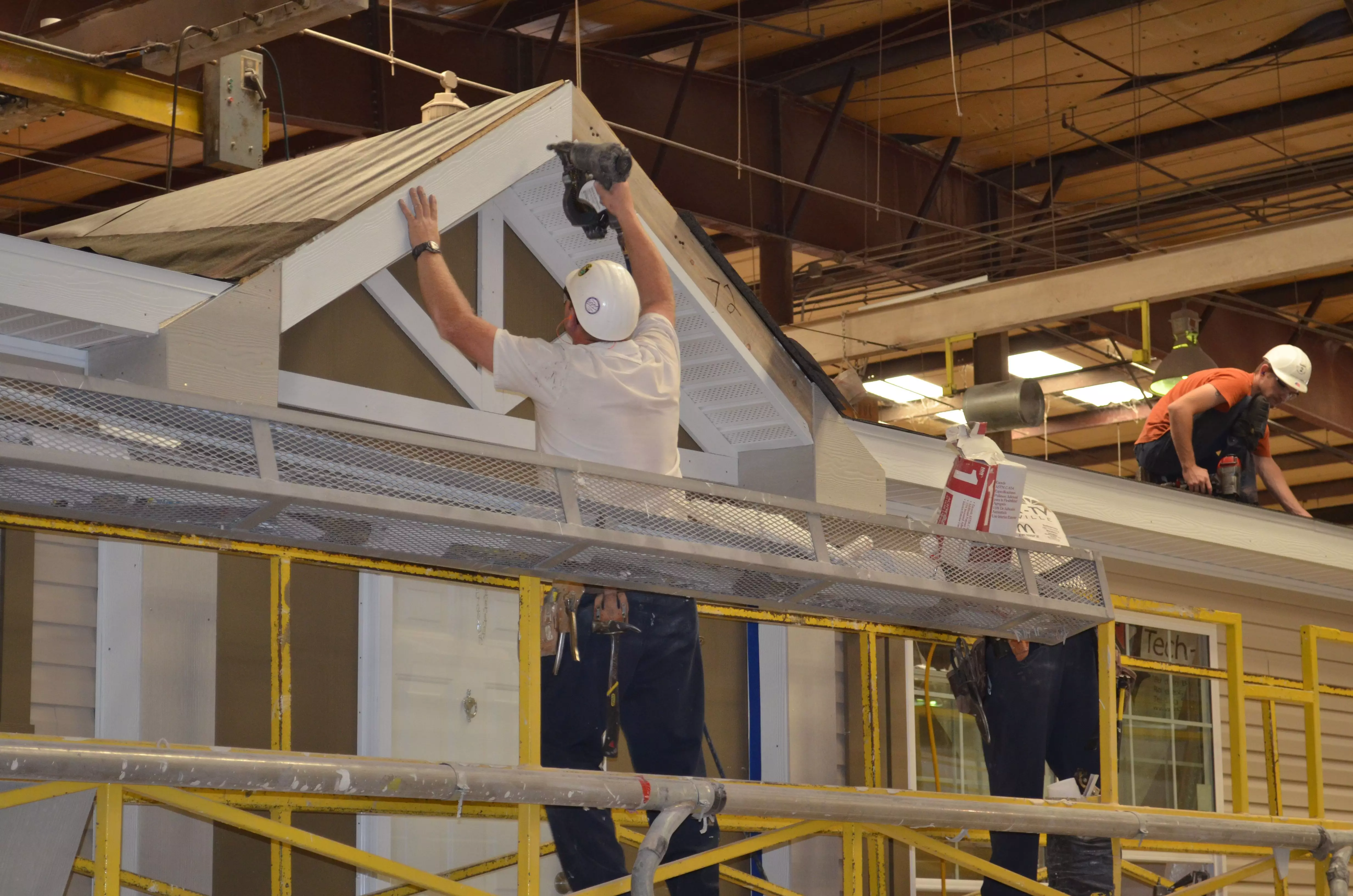 Foto van mannen die een huis bouwen in een fabriek