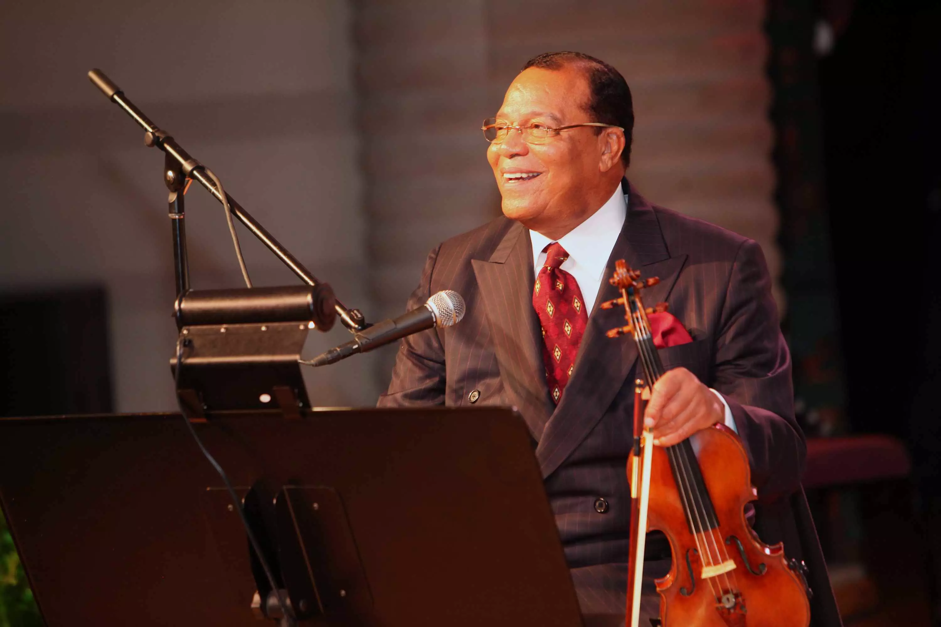 Minister Louis Farrakhan holder en violin og smiler