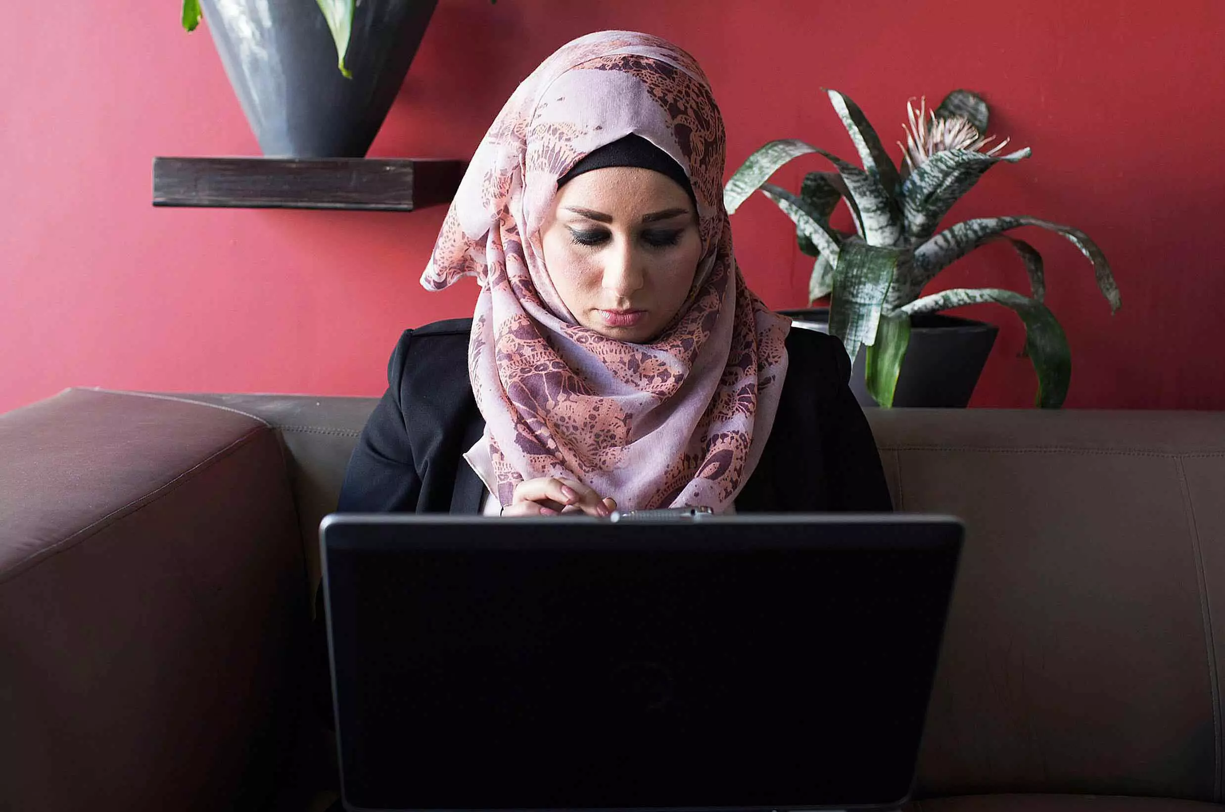 En palestinsk kvinna arbetar online på ett kafé