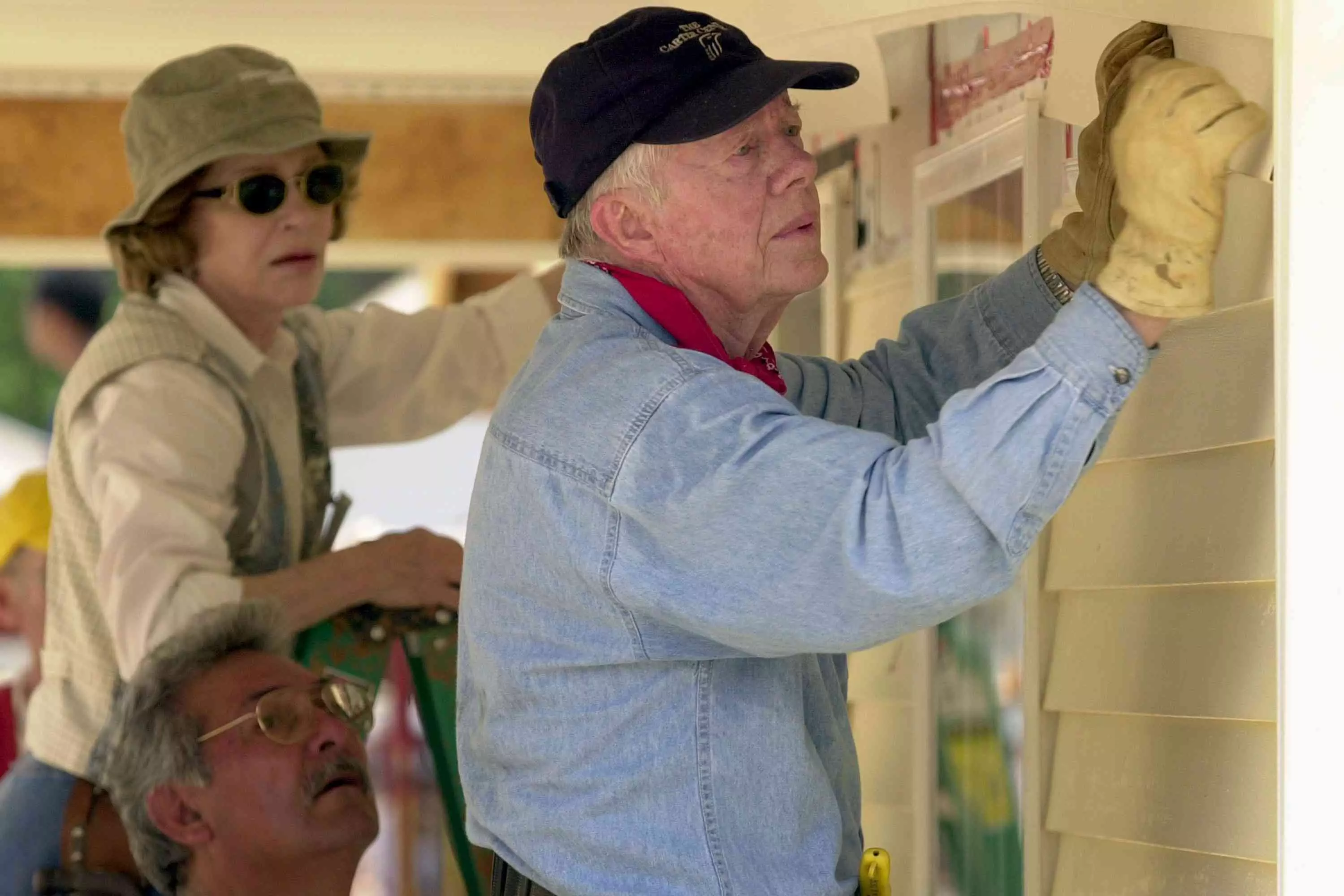 Rais wa zamani wa Marekani Jimmy Carter na mkewe Rosalyn wanashikamana na sehemu ya mbele ya nyumba ya Habitat for Humanity inayojengwa Juni 10, 2003 huko LaGrange, Georgia.