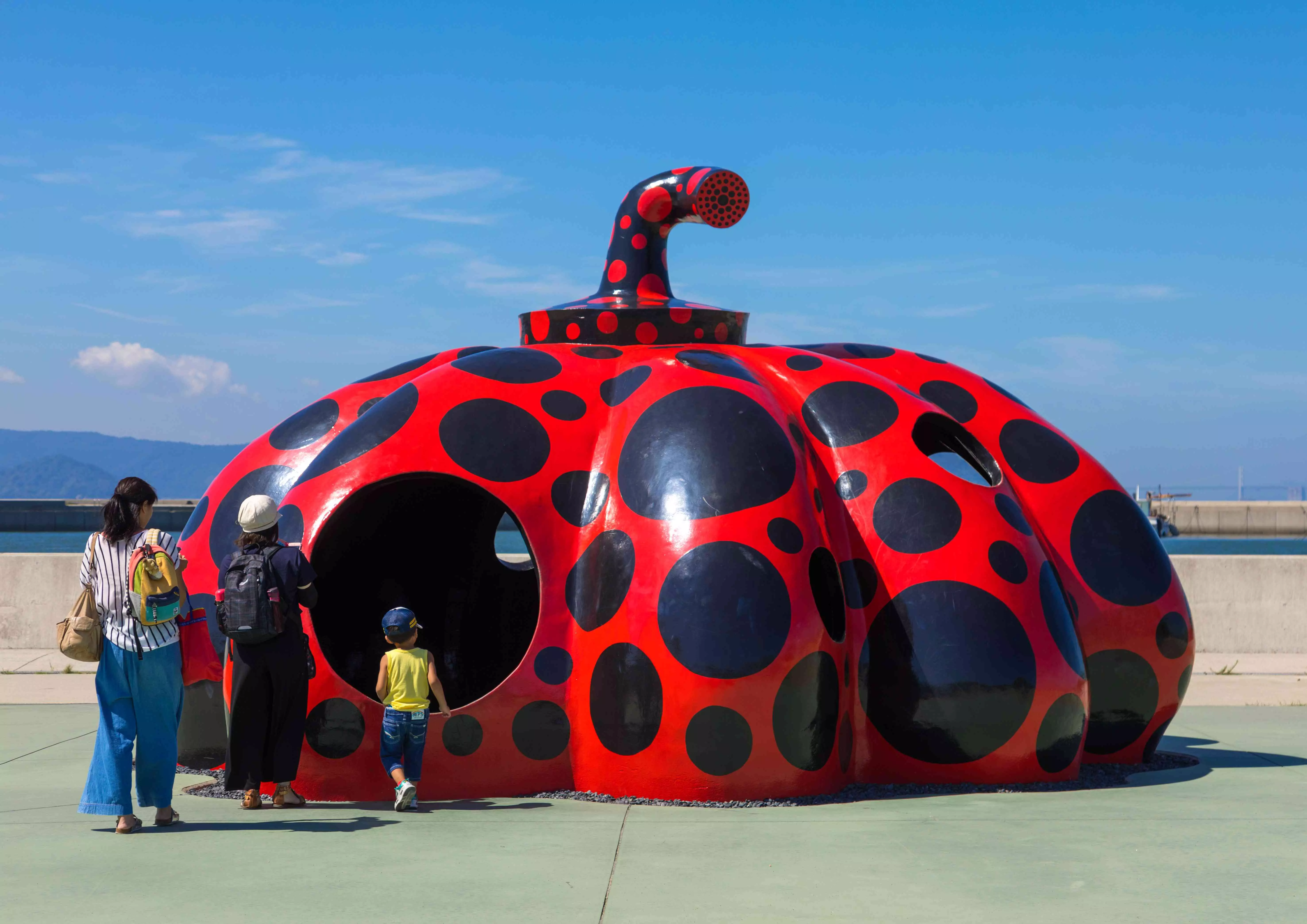 Familia frente a Yayoi Kusama calabaza roja, Mar Interior de Seto, Naoshima, Japón...