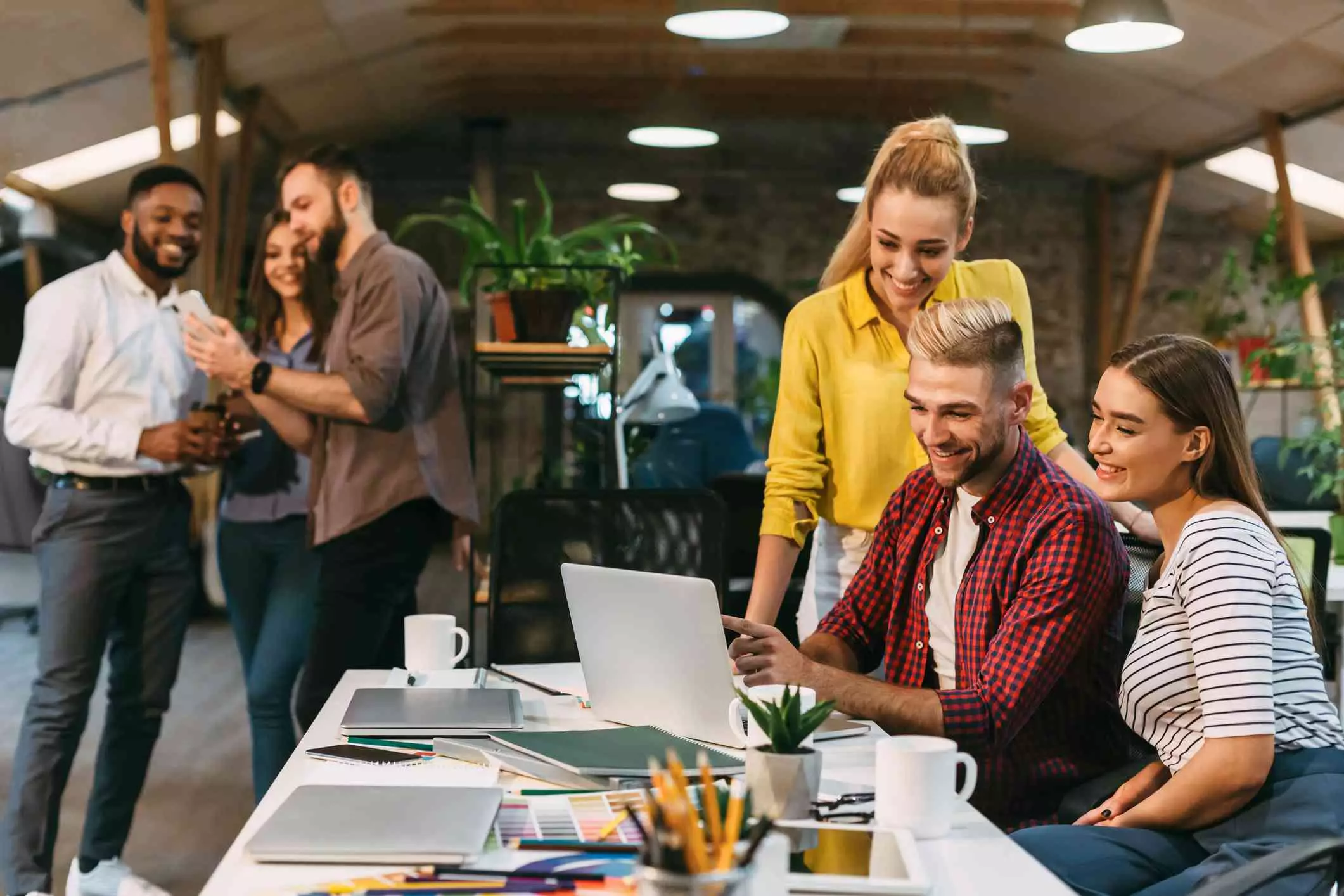 Jóvenes diseñadores web trabajando juntos en la oficina moderna