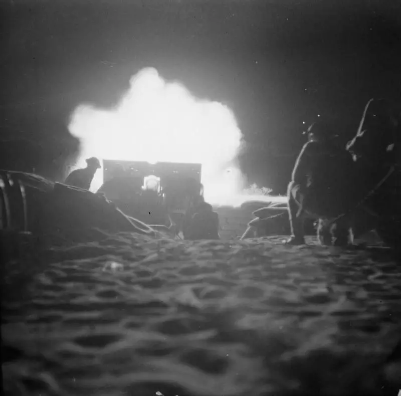 Photographie d'une pièce d'artillerie tirant de nuit.