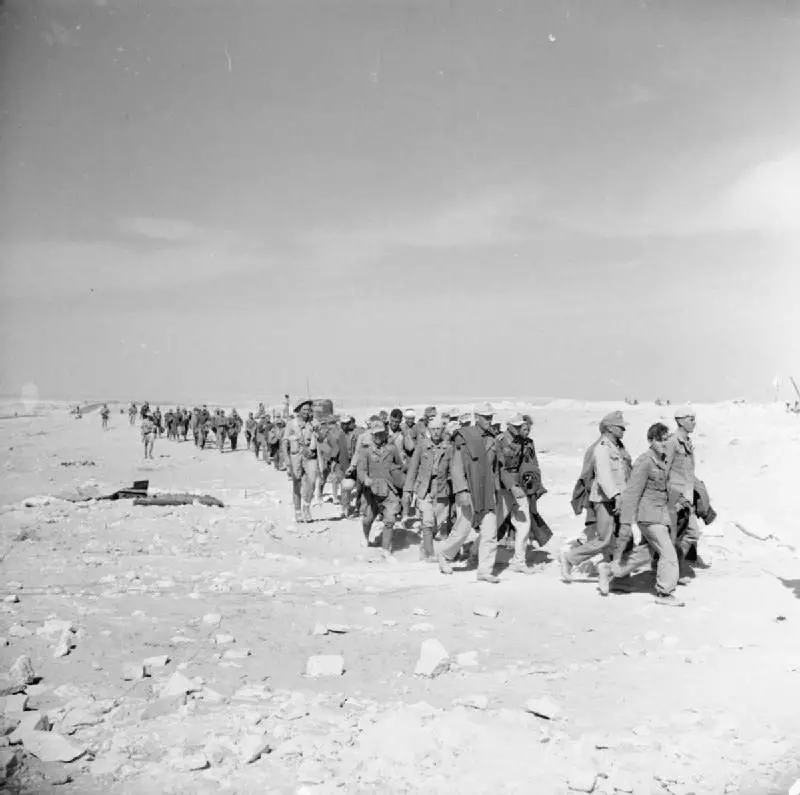 Снимка на колона на германски затворници, маршируващи в пустинята.